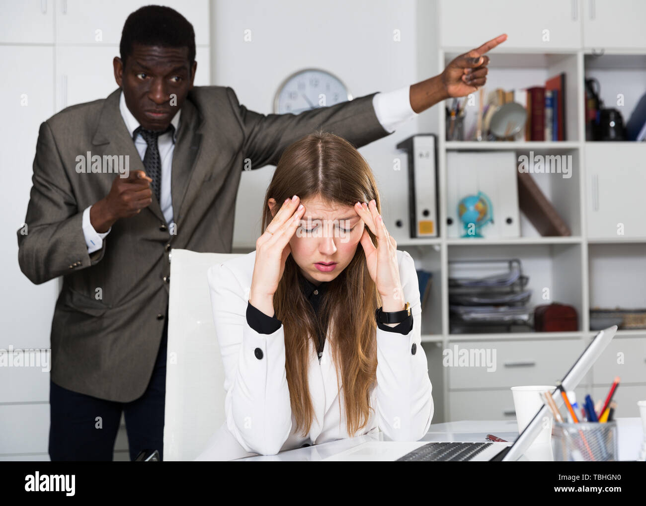 Angry male boss screaming to young female manager during working in ...