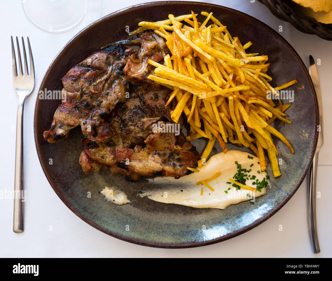 Appetizing roasted lamb meat with French fries and white sauce Stock ...
