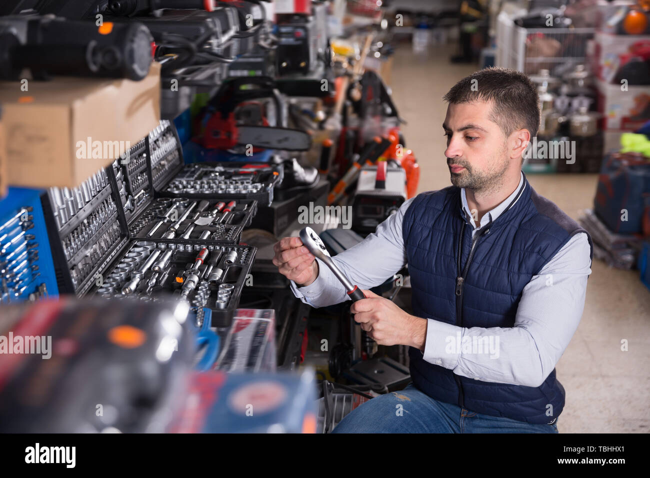 Adult man is buying new ratchet in tools store Stock Photo - Alamy