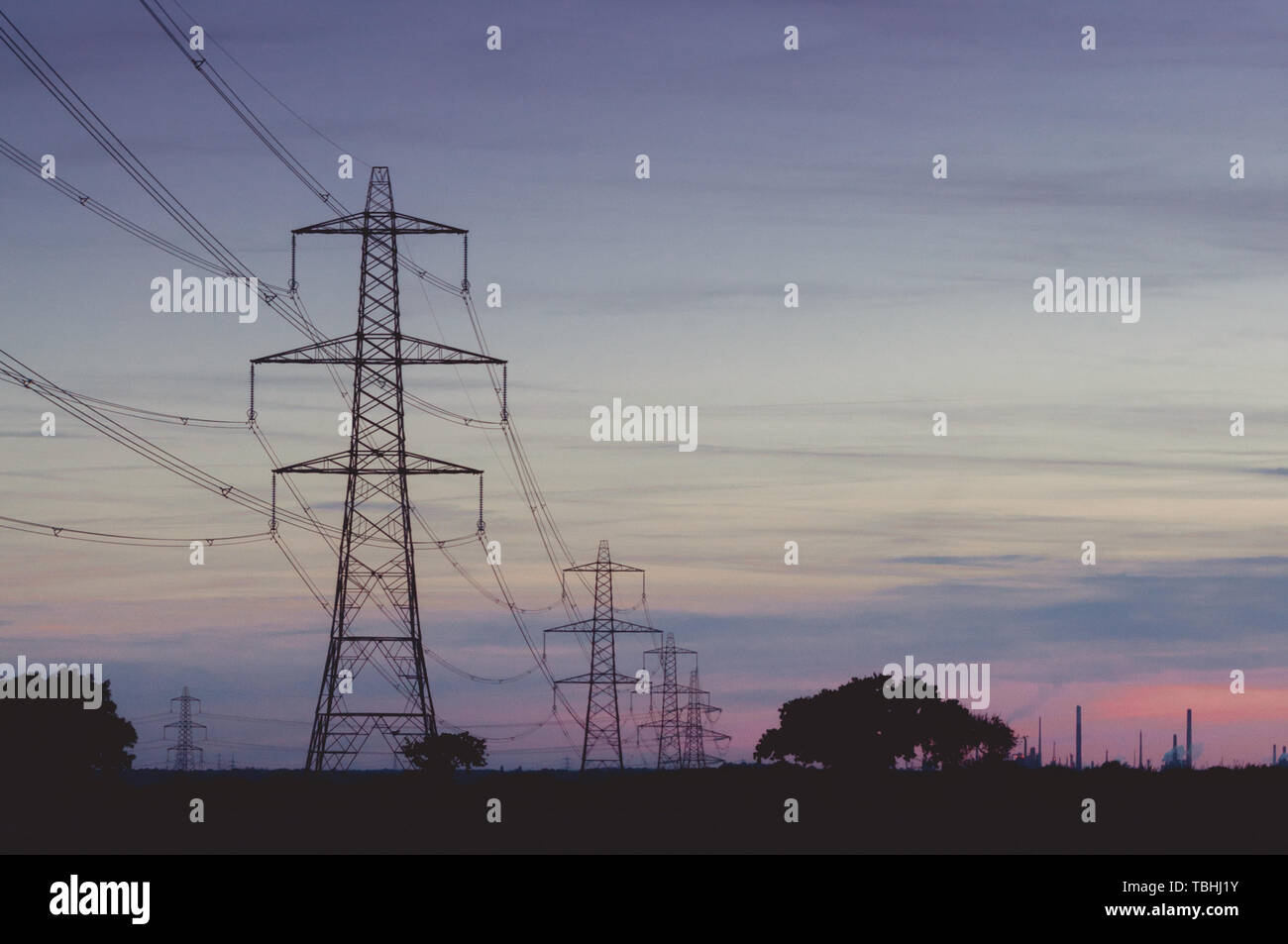 British Electricity pylons at sunset looking back over power station ...