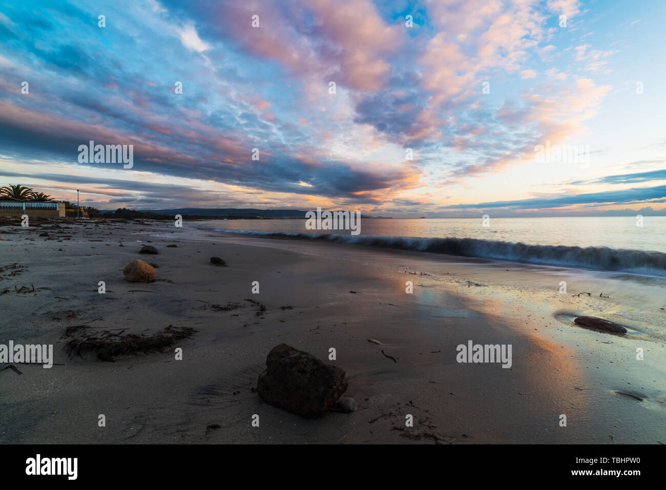 Sand and rocks by the sea at sunset Stock Photo - Alamy
