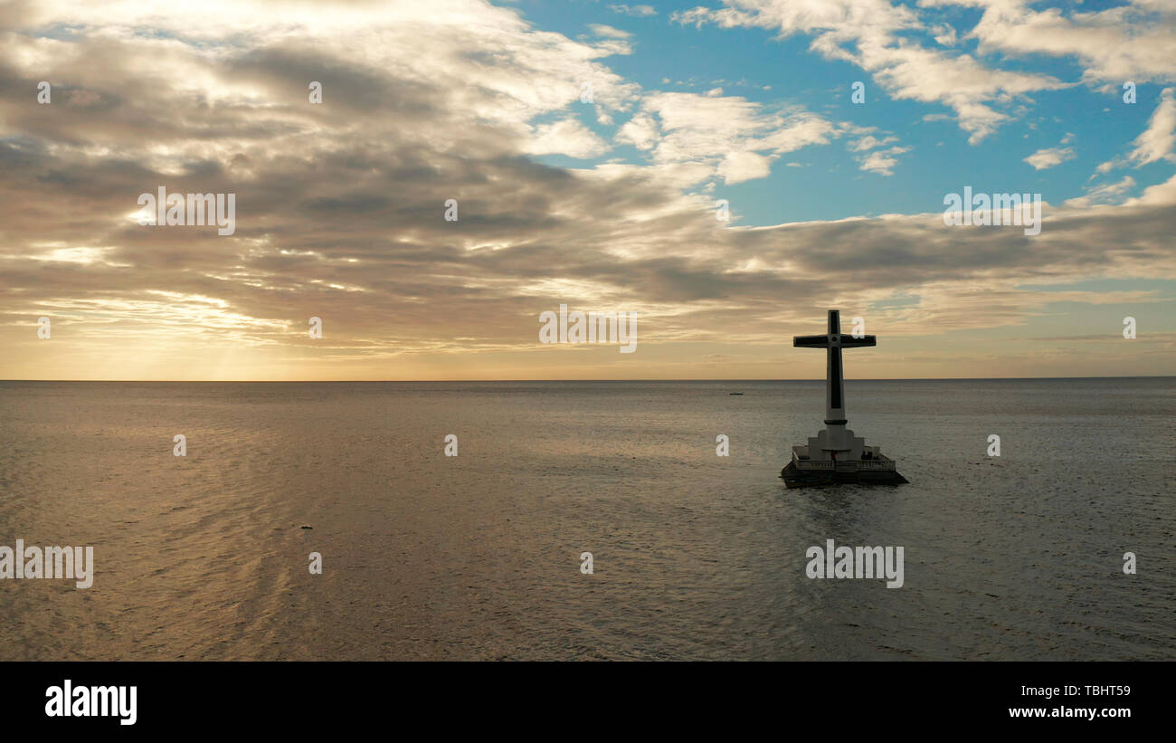 Catholic cross in sunken cemetery in the sea at sunset, aerial view ...