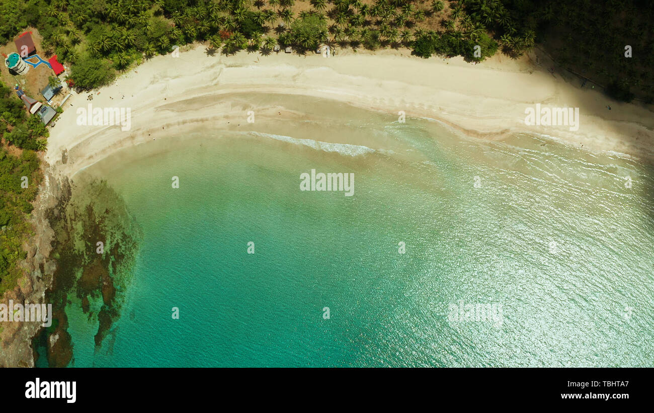 Tropical sandy beach with tourists in blue water, aerial view. Nagtabon ...