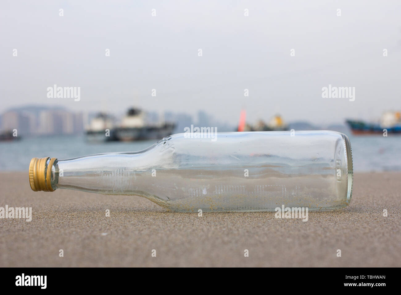 A white empty bottle by the sea Stock Photo - Alamy