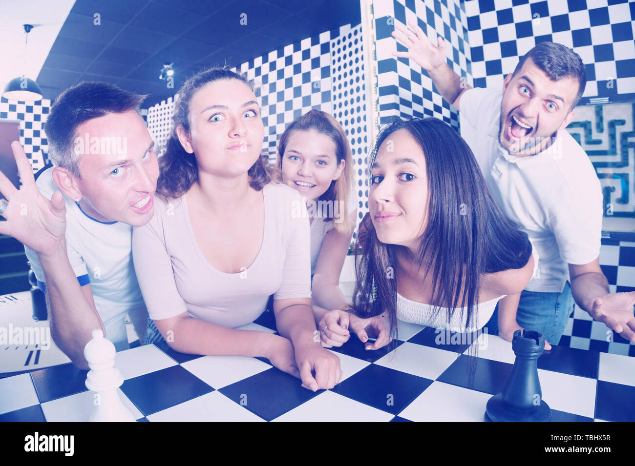 Group of young people having fun in the escape room stylized under ...