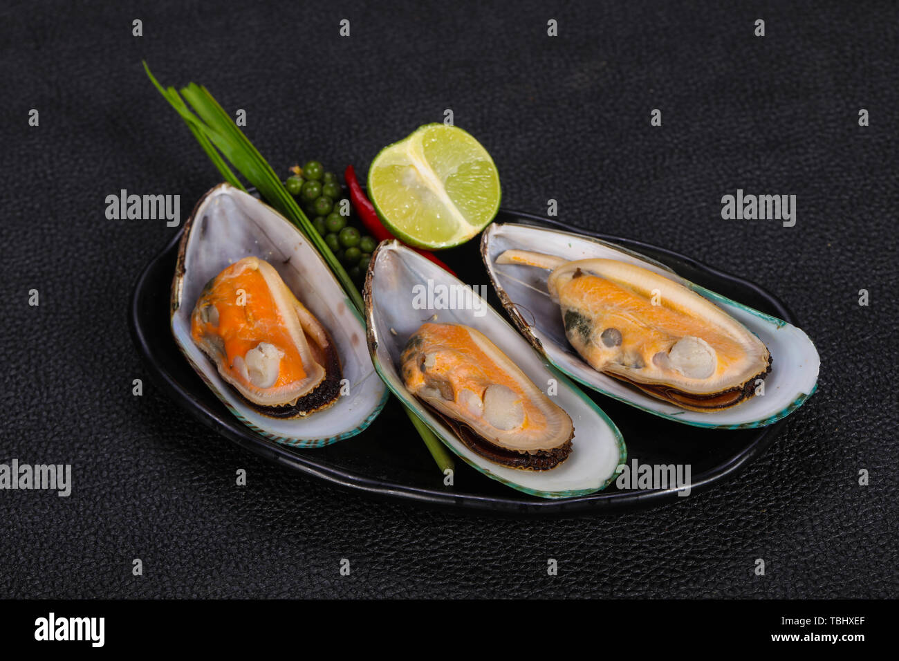 Half mussels with lime and green pepper Stock Photo - Alamy