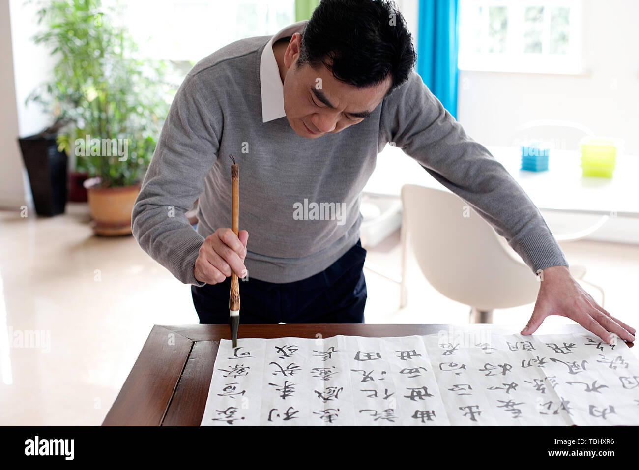 An elderly man practicing calligraphy Stock Photo - Alamy