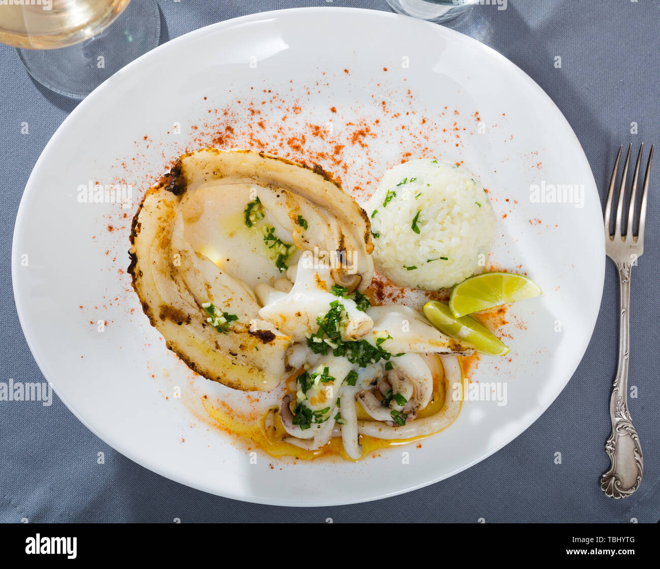 Roasted cuttlefish with rice, lime slices and chopped herbs Stock Photo ...