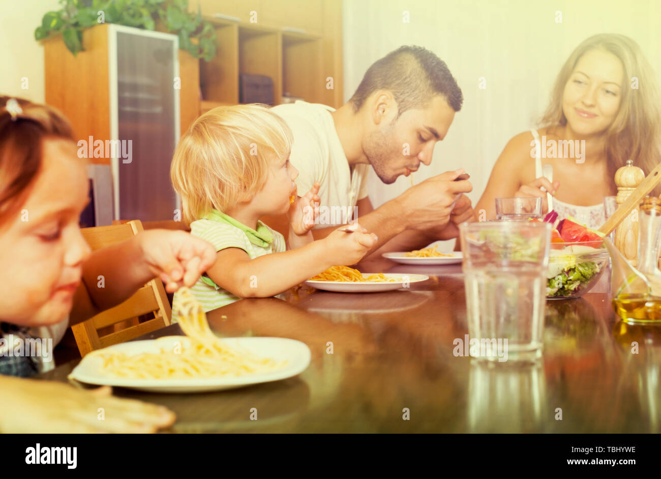 ordinary family of four eating spaghetti Stock Photo - Alamy