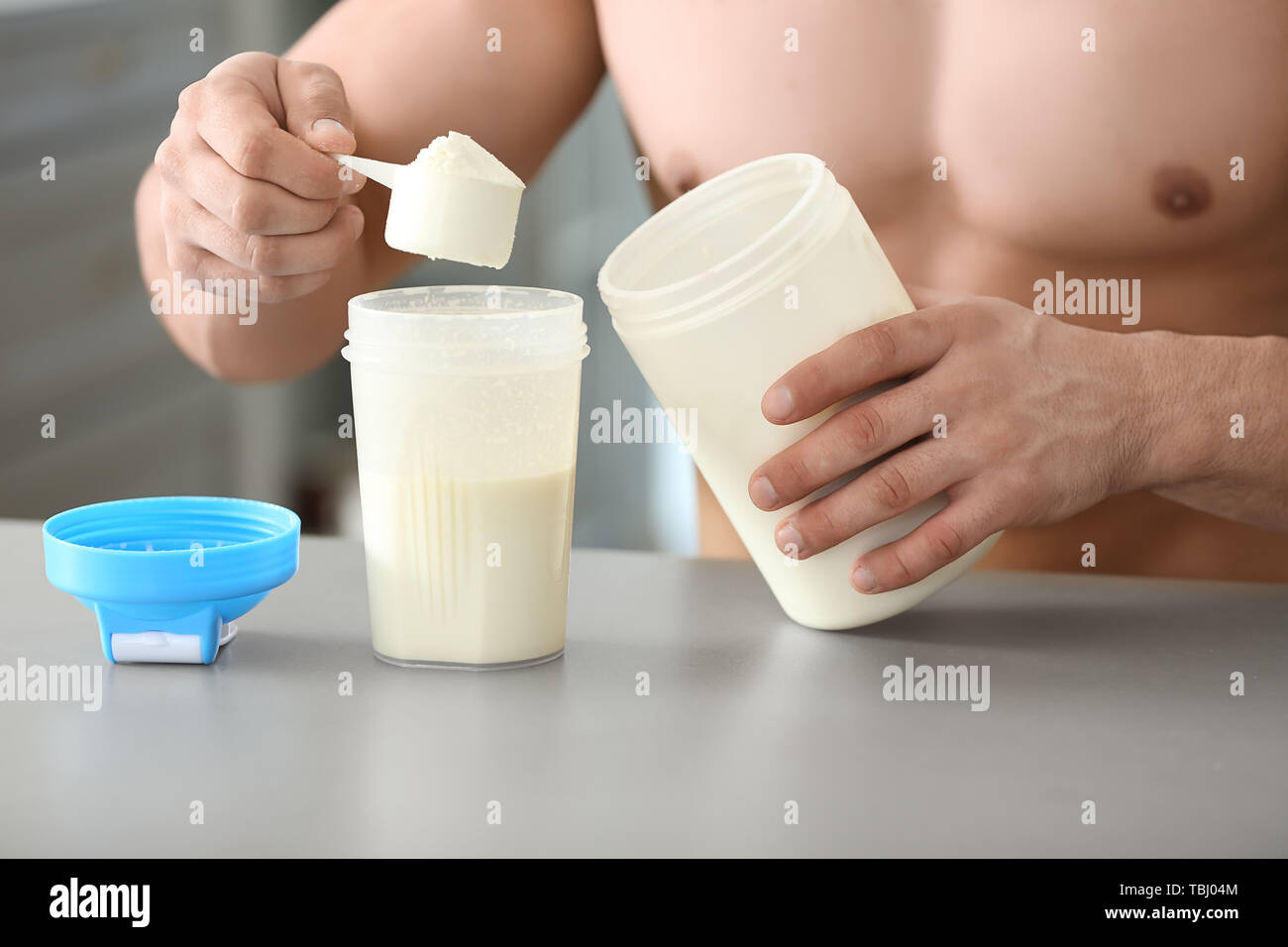 Sporty man making protein shake at home Stock Photo - Alamy