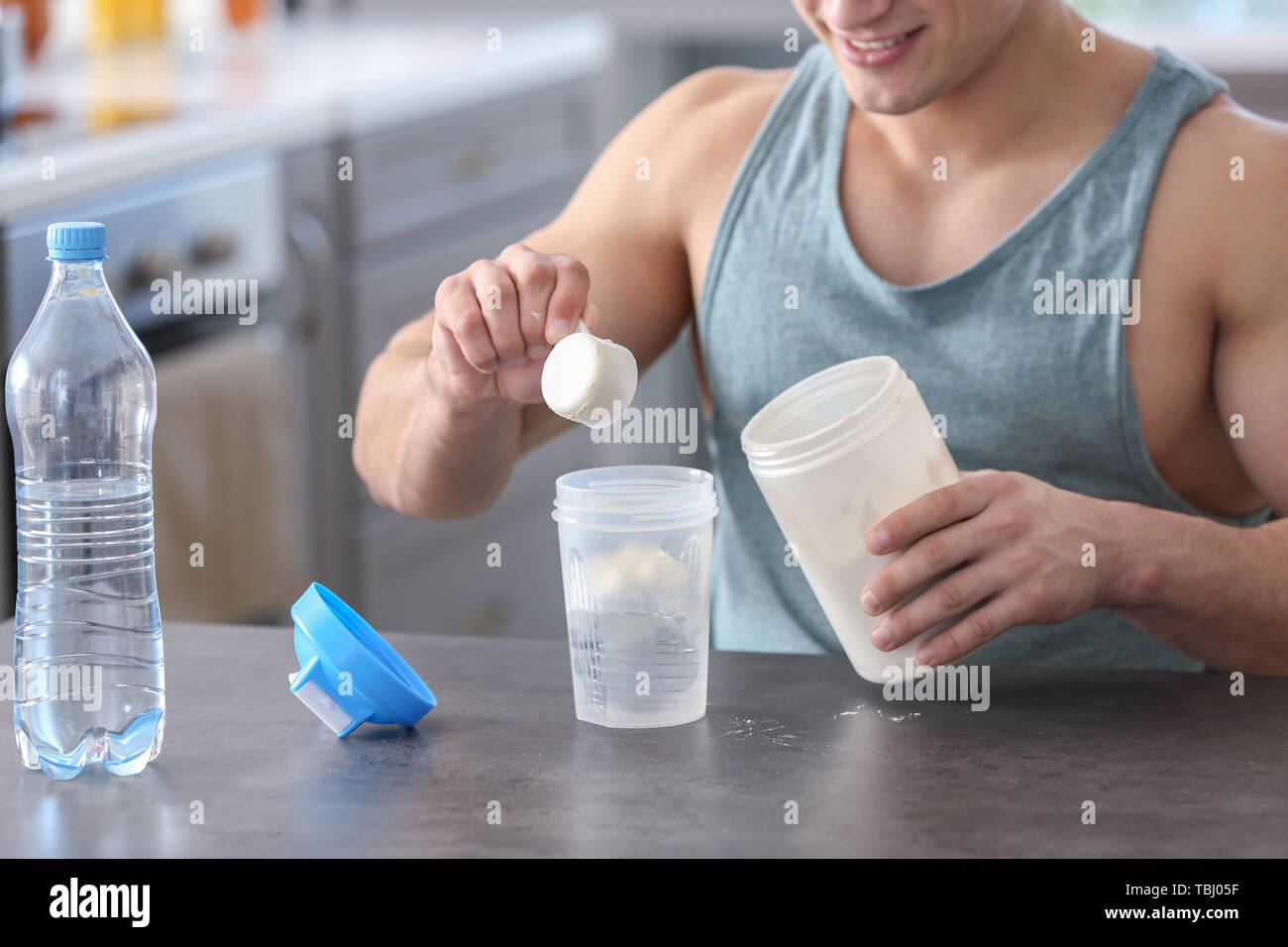Sporty man making protein shake at home Stock Photo - Alamy