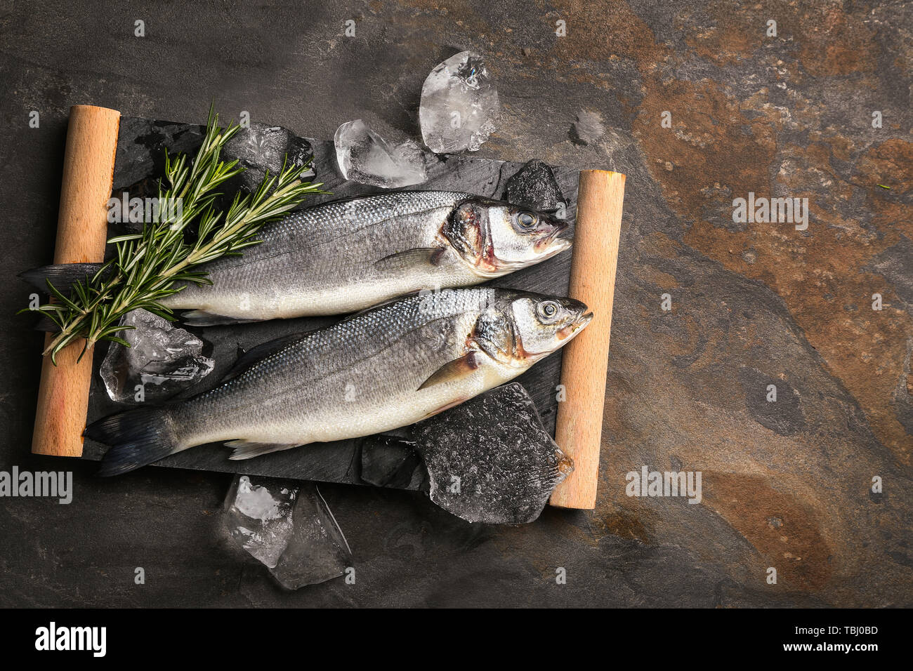 Fresh fish with ice on grey table Stock Photo - Alamy