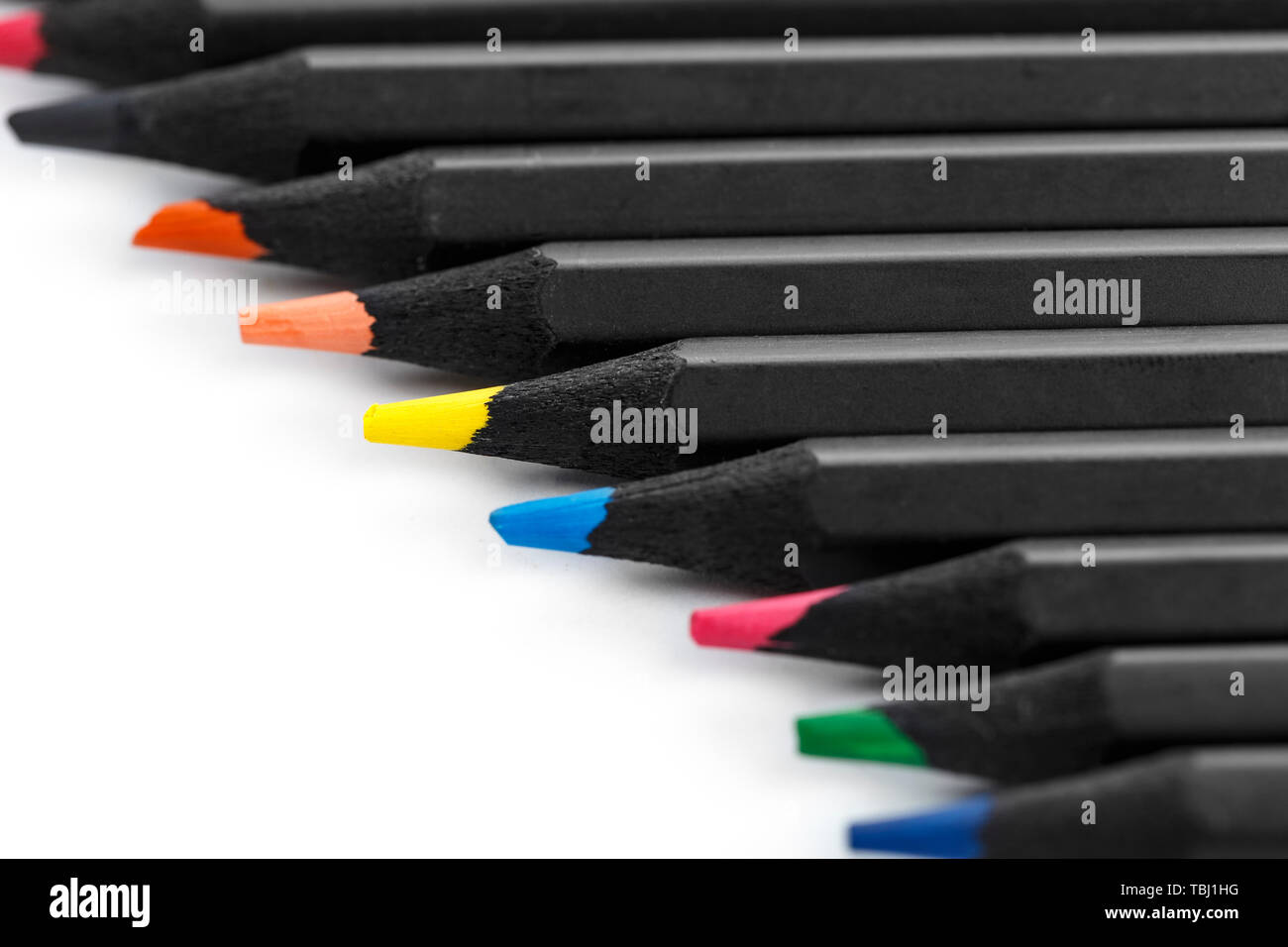 Multi-colored pencils on a white background laid out in a row. isolated ...