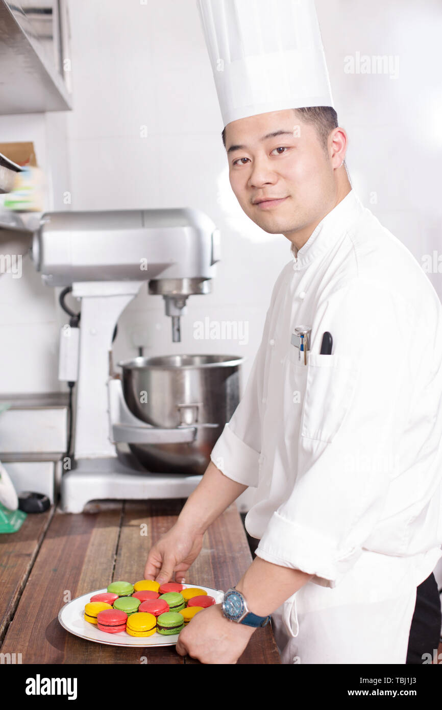 young chinese man chelf making food in modern kitchen Stock Photo - Alamy