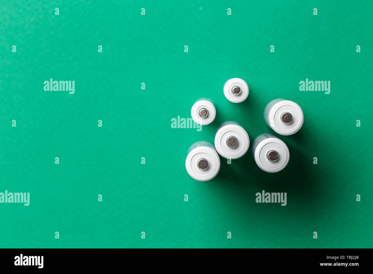 white batteries on a green background, top view. space for text Stock ...