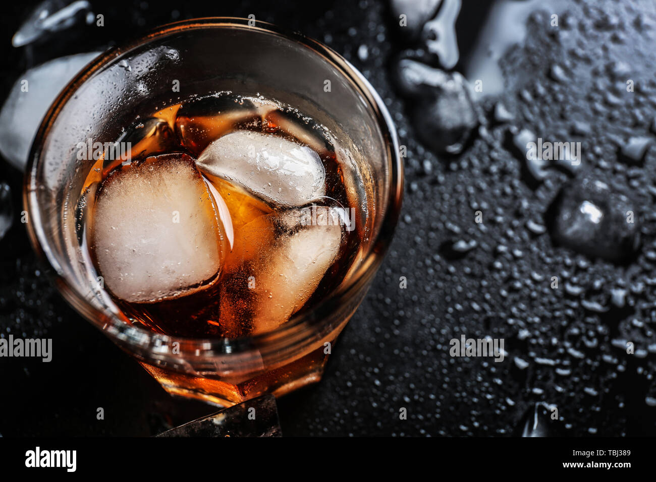 Glass of cold whiskey on dark background Stock Photo - Alamy