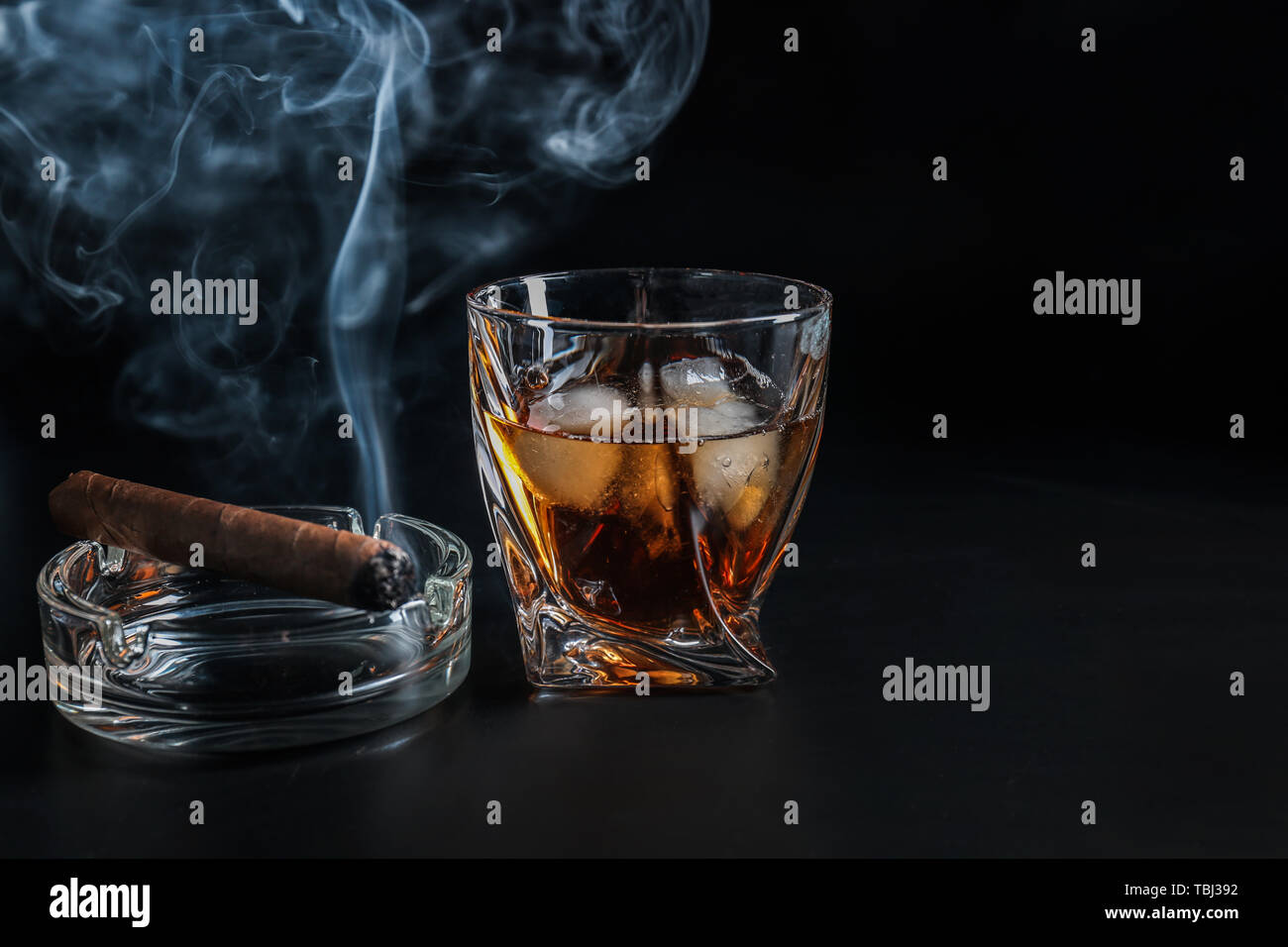 Glass of cold whiskey with cigar on dark background Stock Photo - Alamy