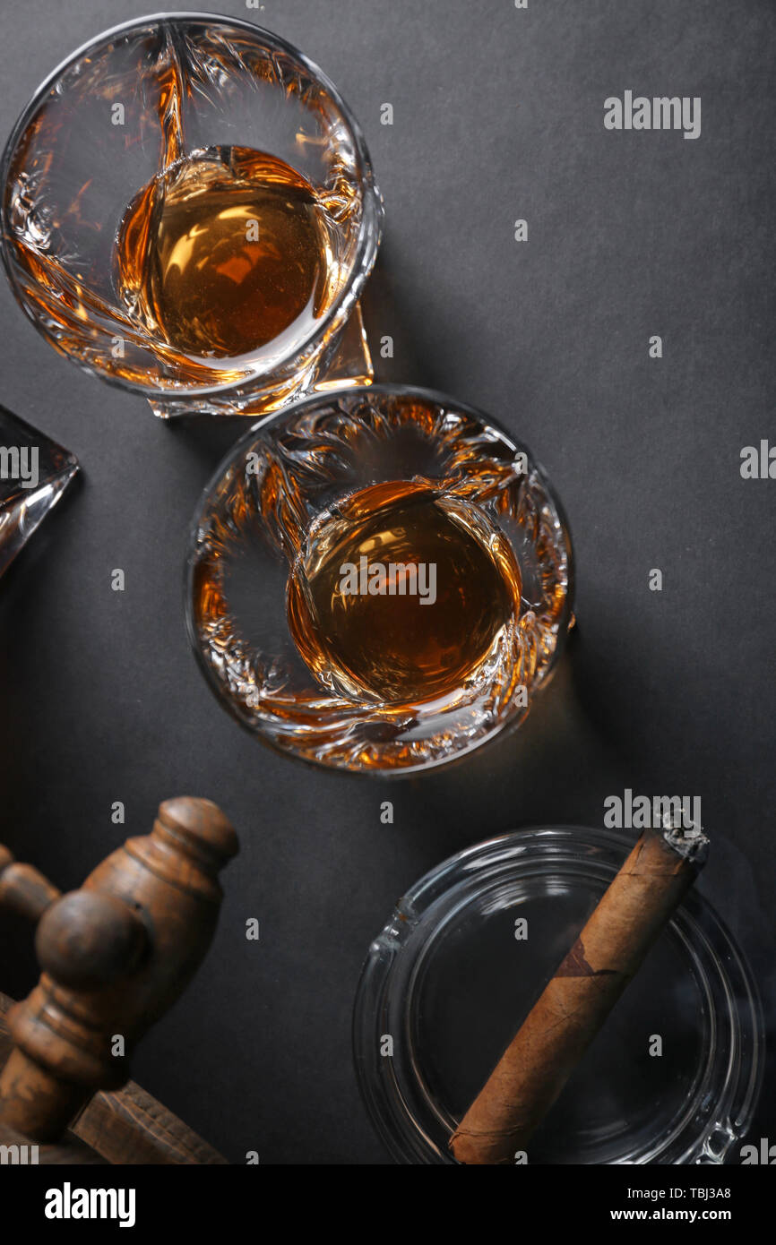 Glasses of cold whiskey with cigar and barrel on dark background Stock ...