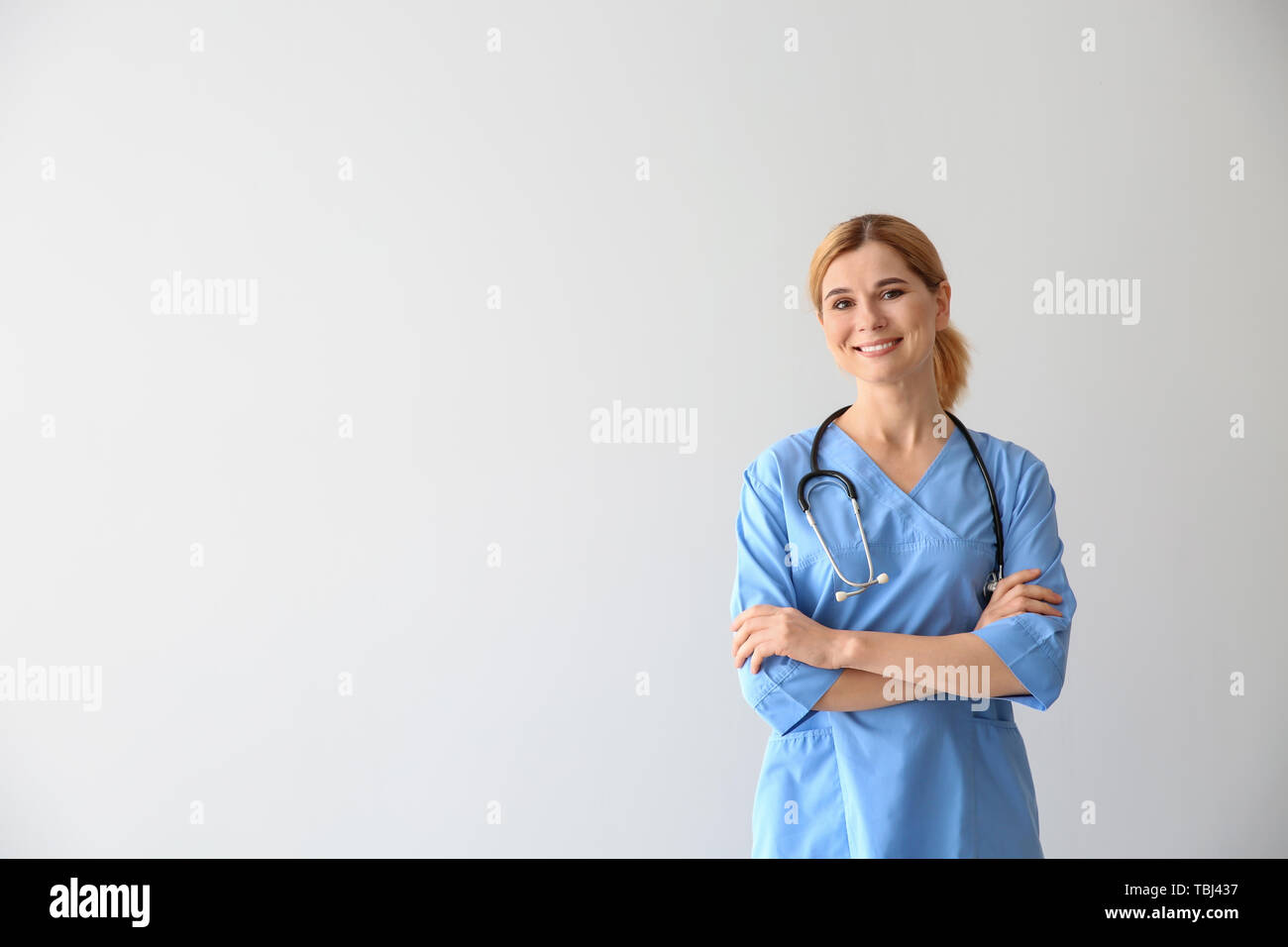 Portrait of beautiful gynecologist on light background Stock Photo - Alamy