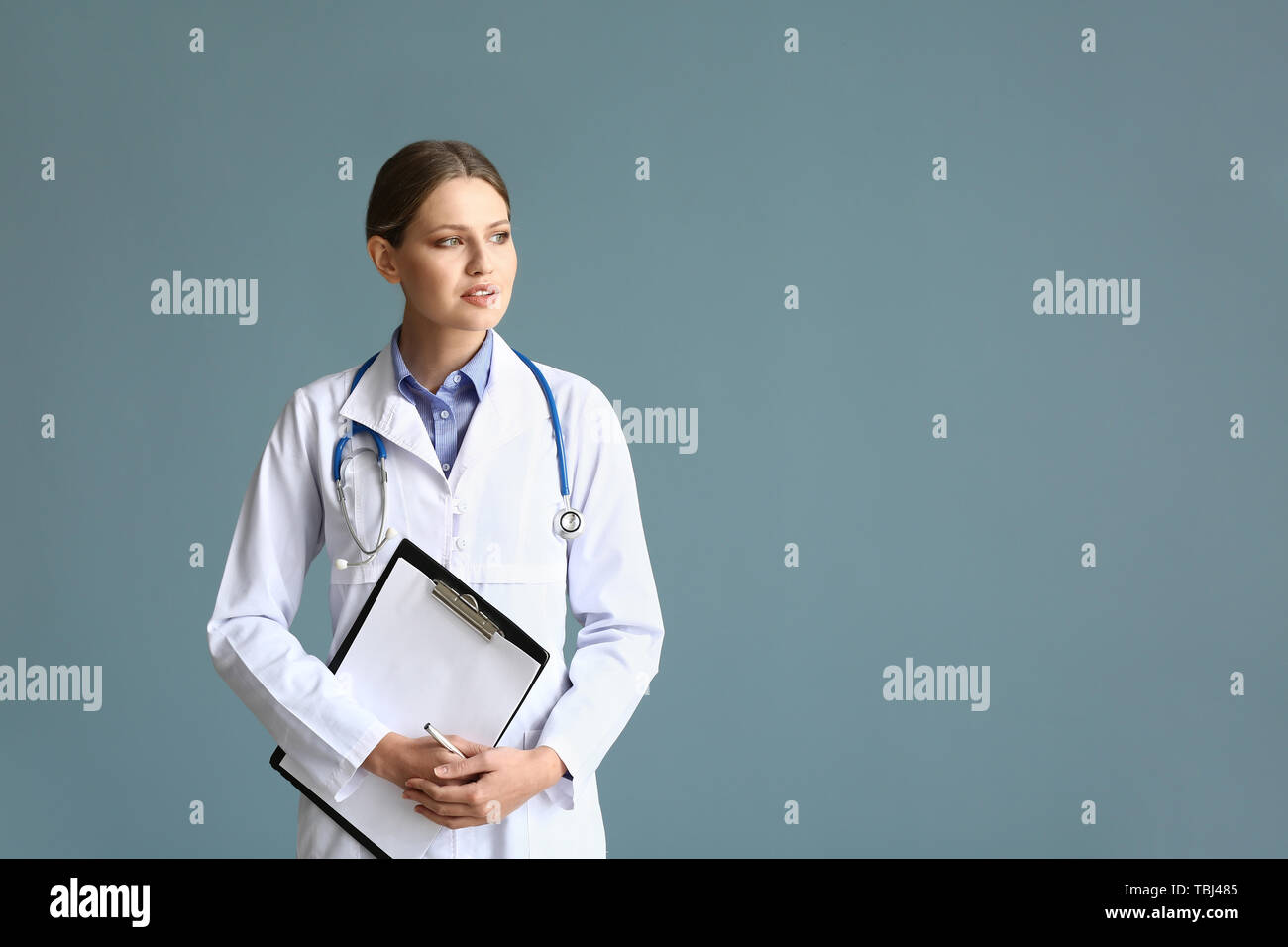 Portrait of young gynecologist on grey background Stock Photo - Alamy