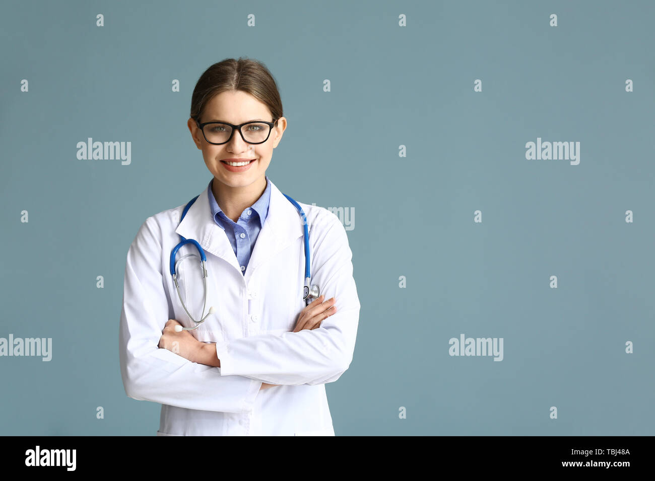 Portrait of young gynecologist on grey background Stock Photo - Alamy