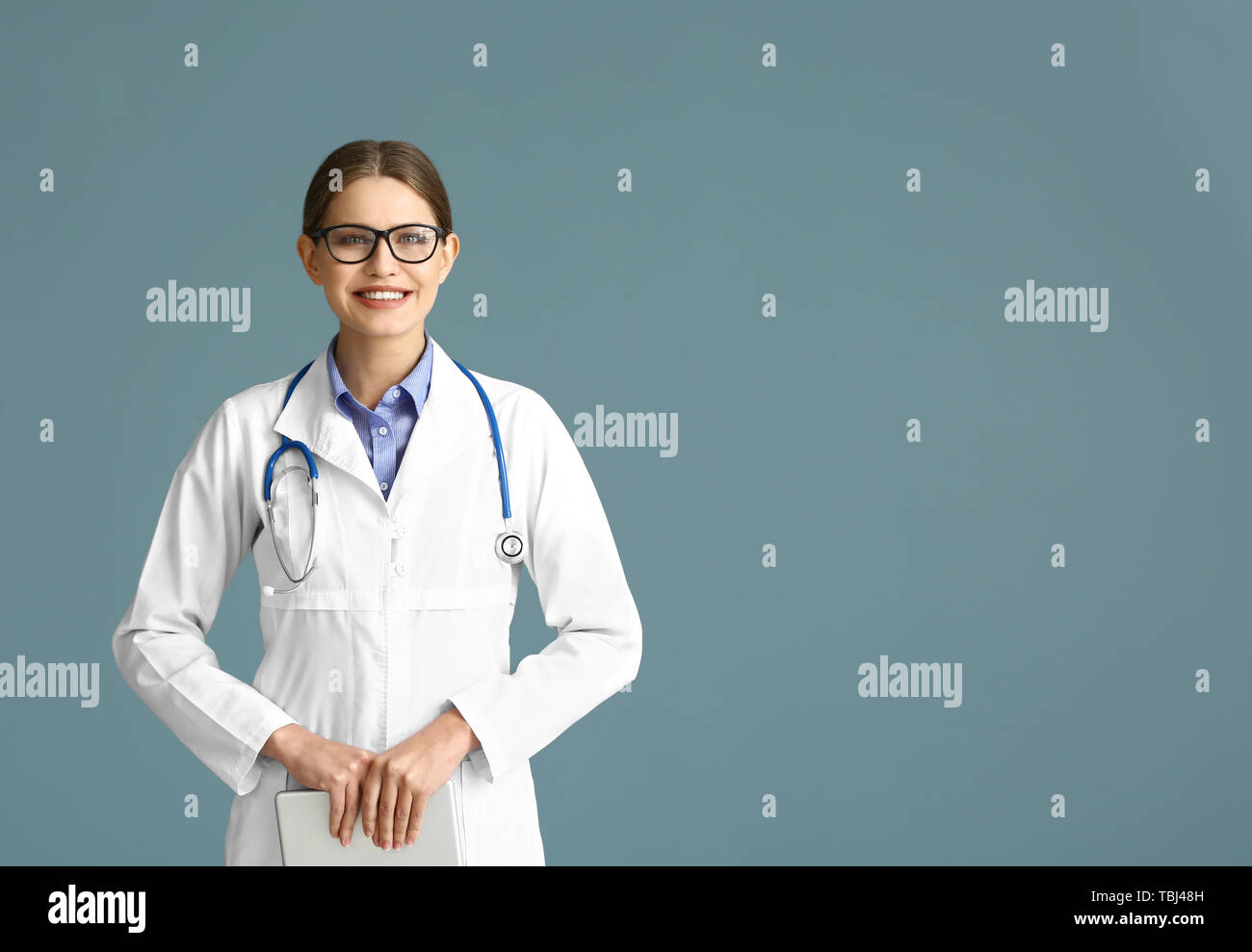 Portrait of young gynecologist on grey background Stock Photo - Alamy