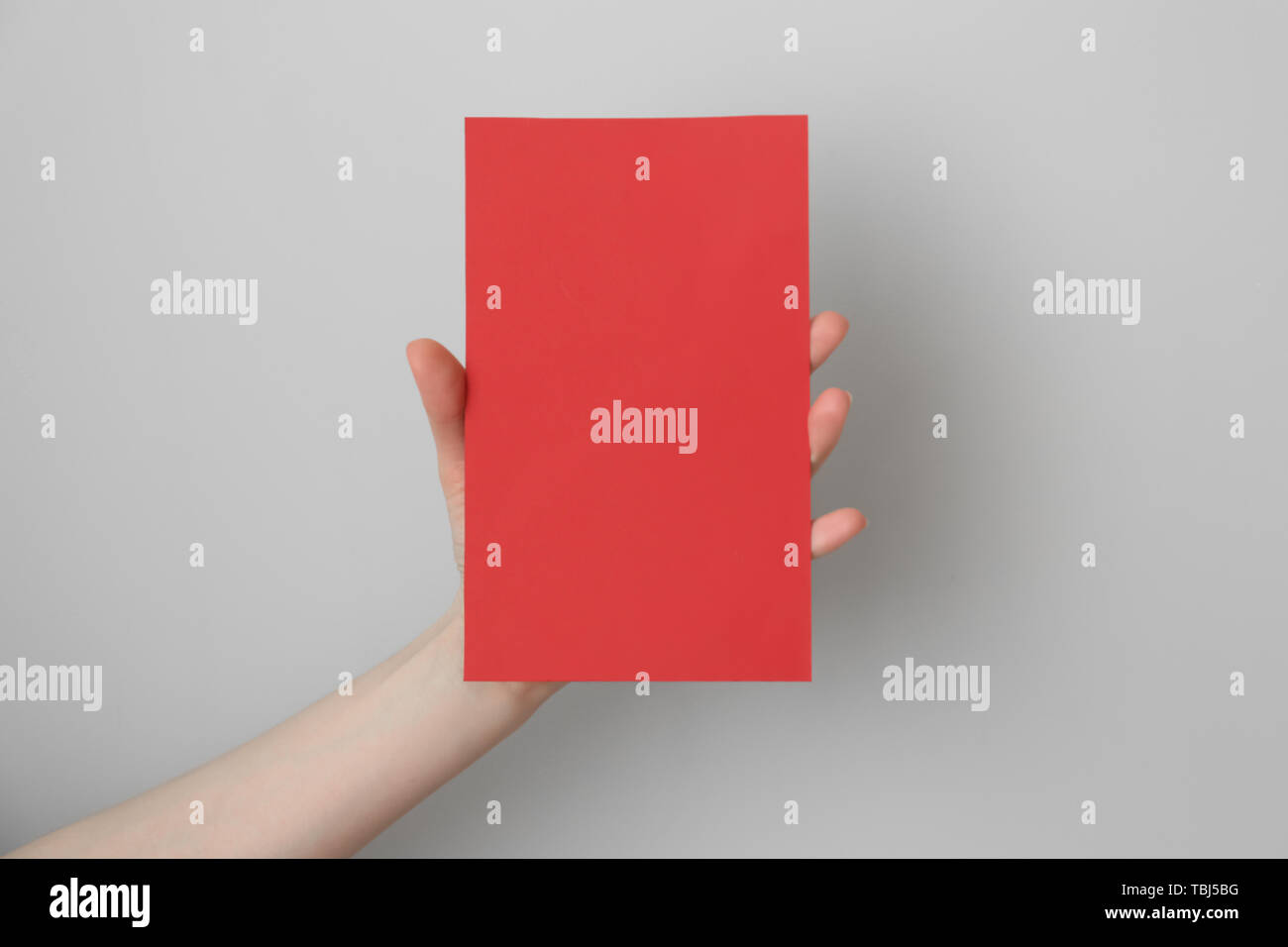 Female hand with blank invitation card on light background Stock Photo ...