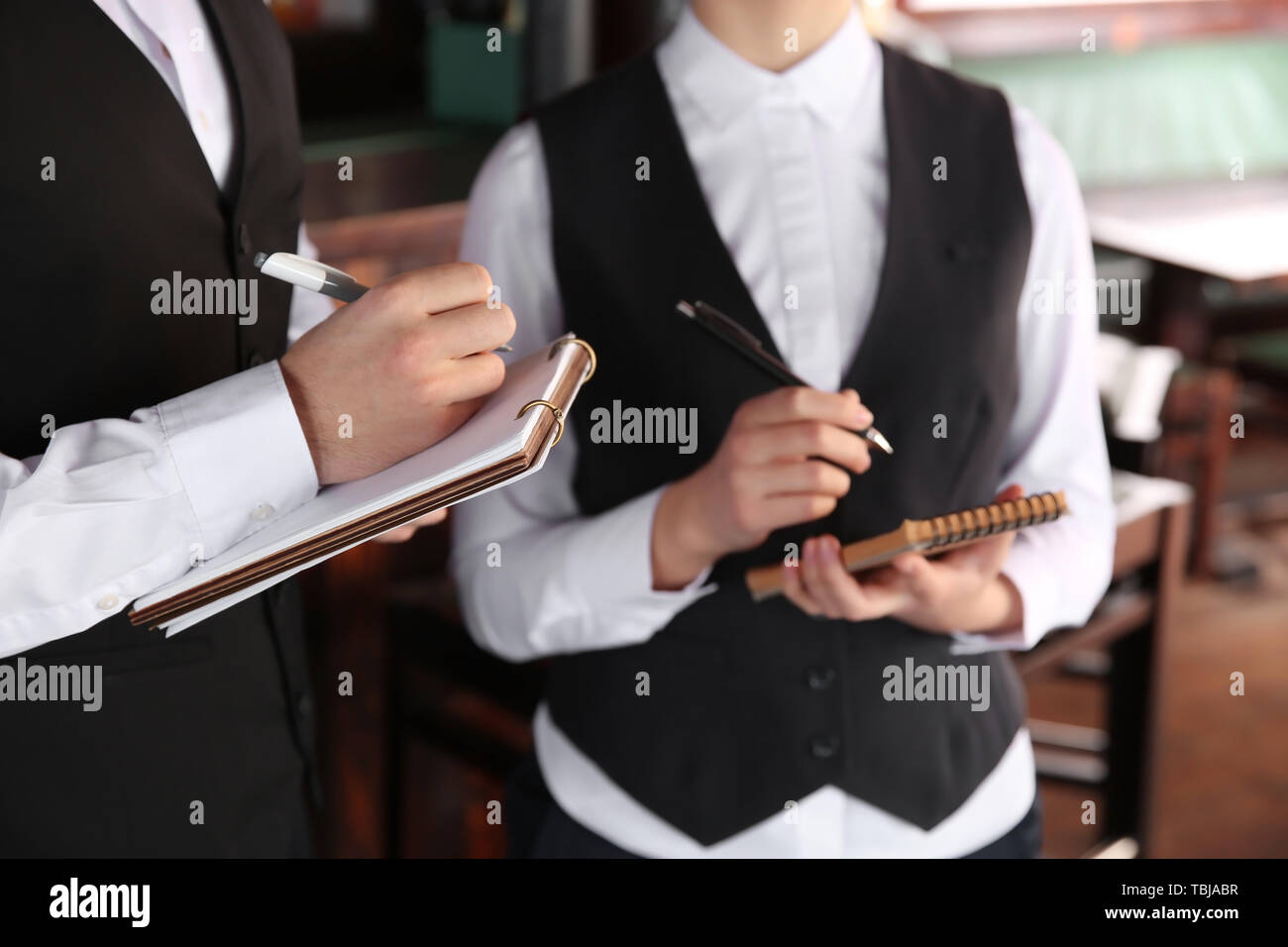 Young waiters with notebooks in restaurant Stock Photo - Alamy