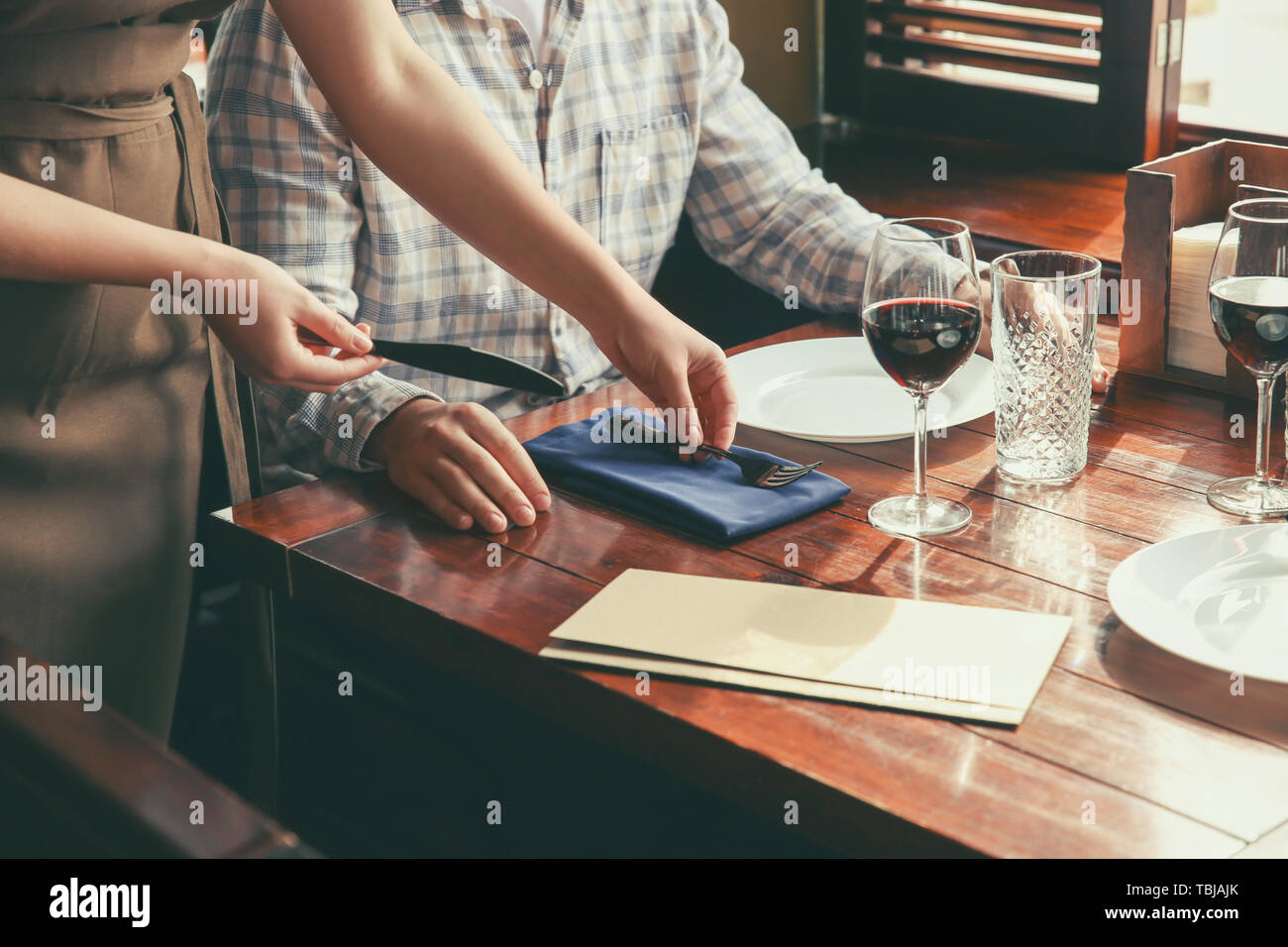 Waiter serving guest in restaurant Stock Photo - Alamy
