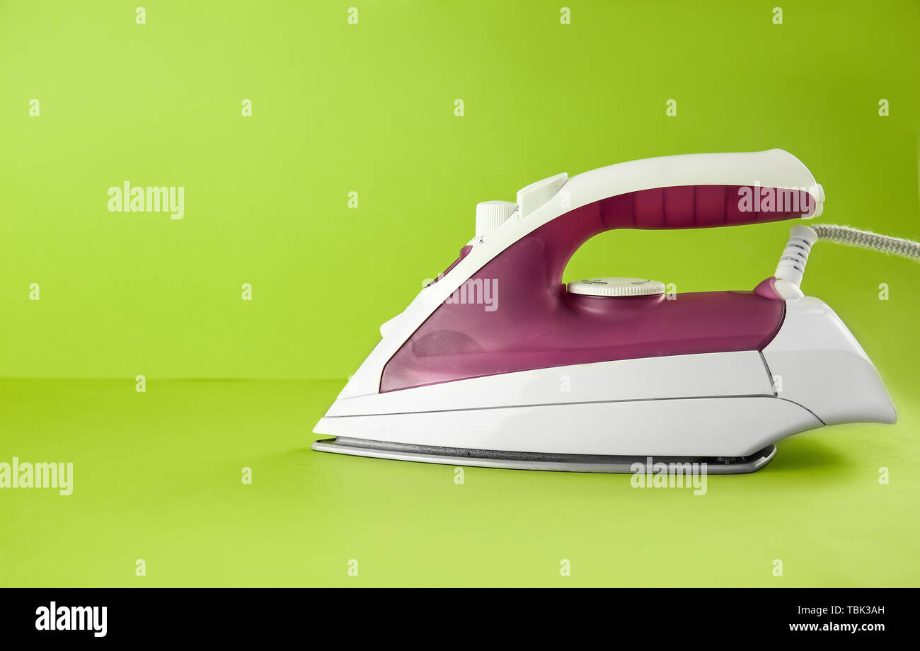 Modern iron on color background Stock Photo - Alamy