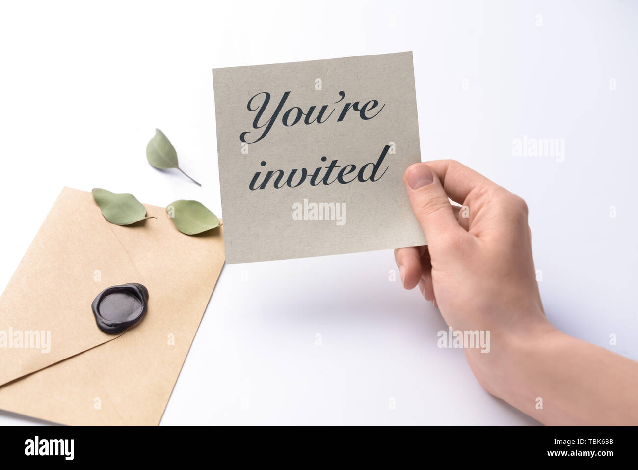 Female hand with invitation and envelope on white background Stock ...