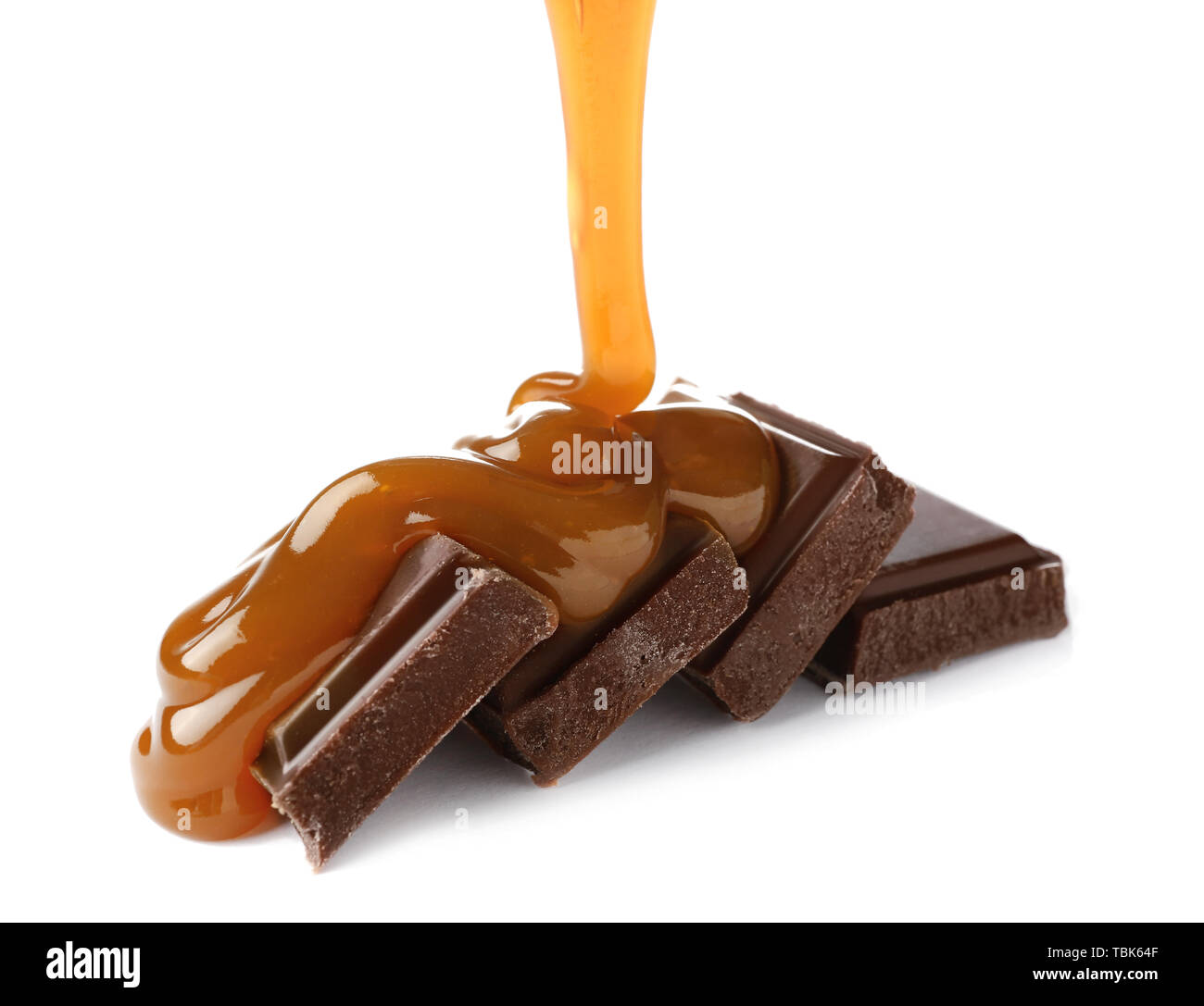 Pouring of liquid caramel onto chocolate on white background Stock ...