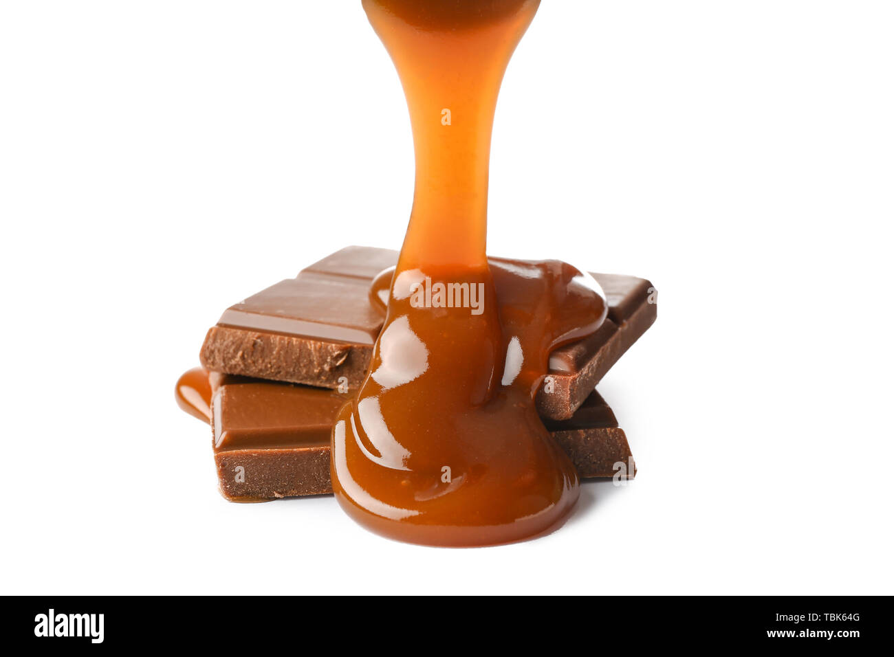 Pouring of liquid caramel onto chocolate on white background Stock ...