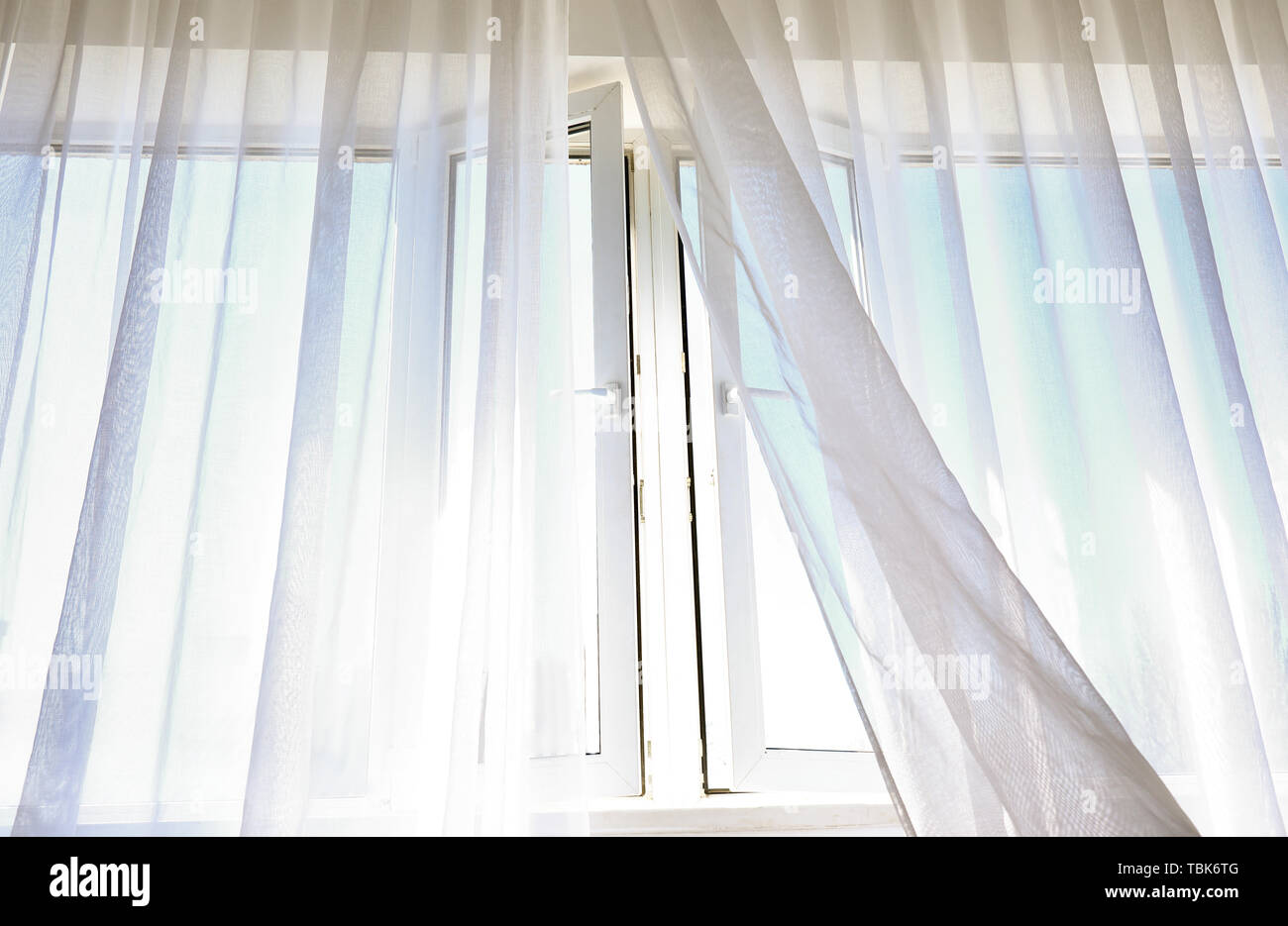 Open window with light curtains in room Stock Photo - Alamy