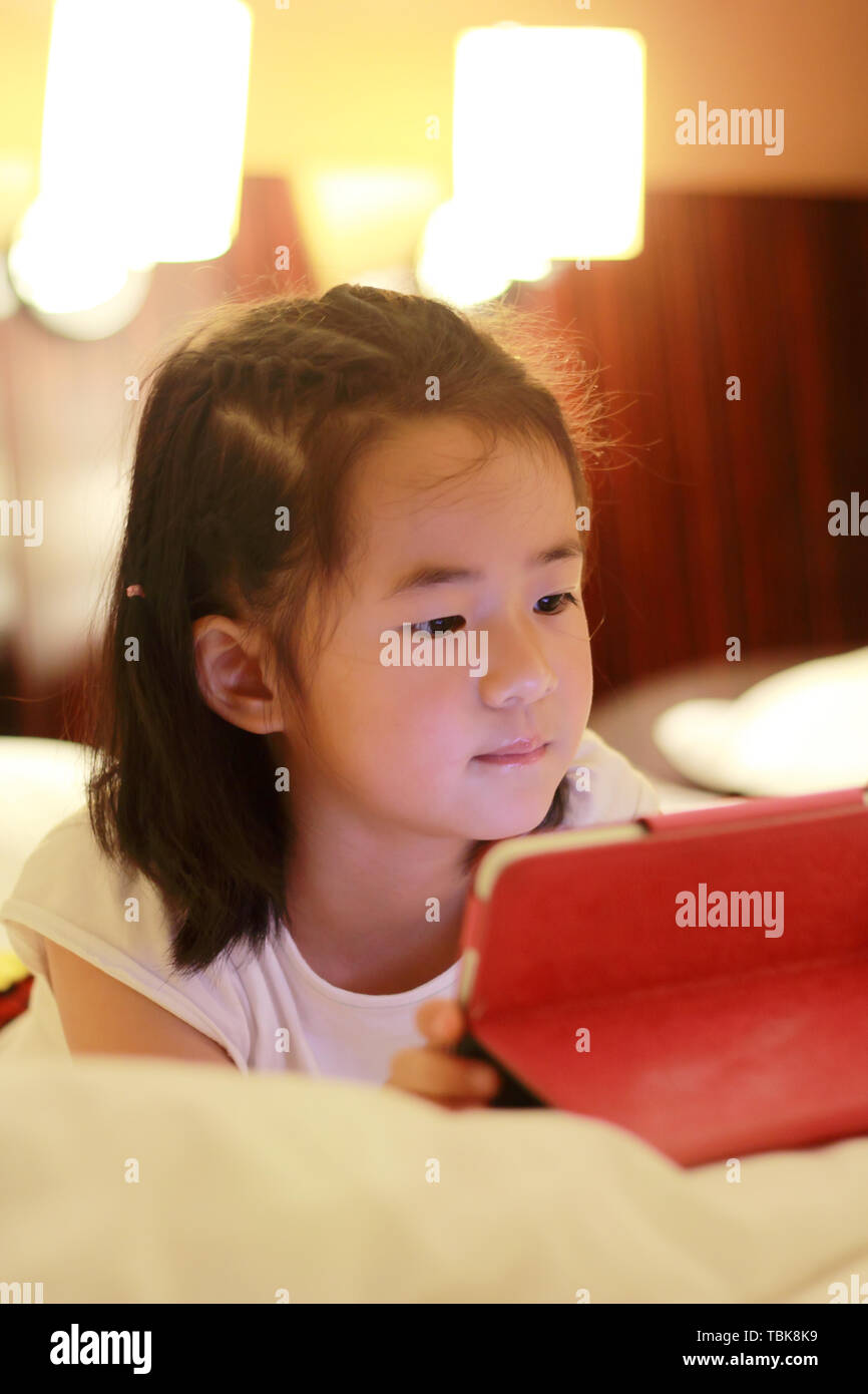 Little girl playing tablet Stock Photo - Alamy