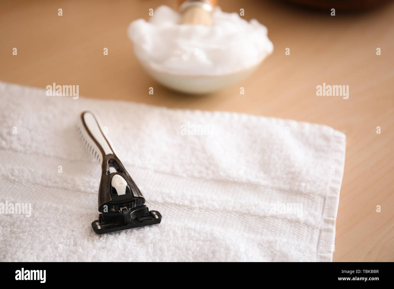 Towel with razor on table Stock Photo - Alamy
