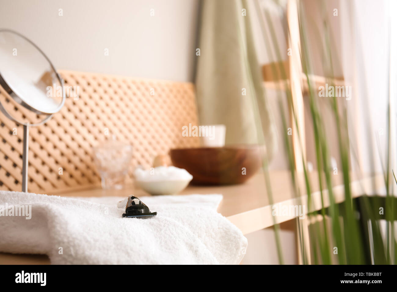 Towel with razor on table in bathroom Stock Photo - Alamy