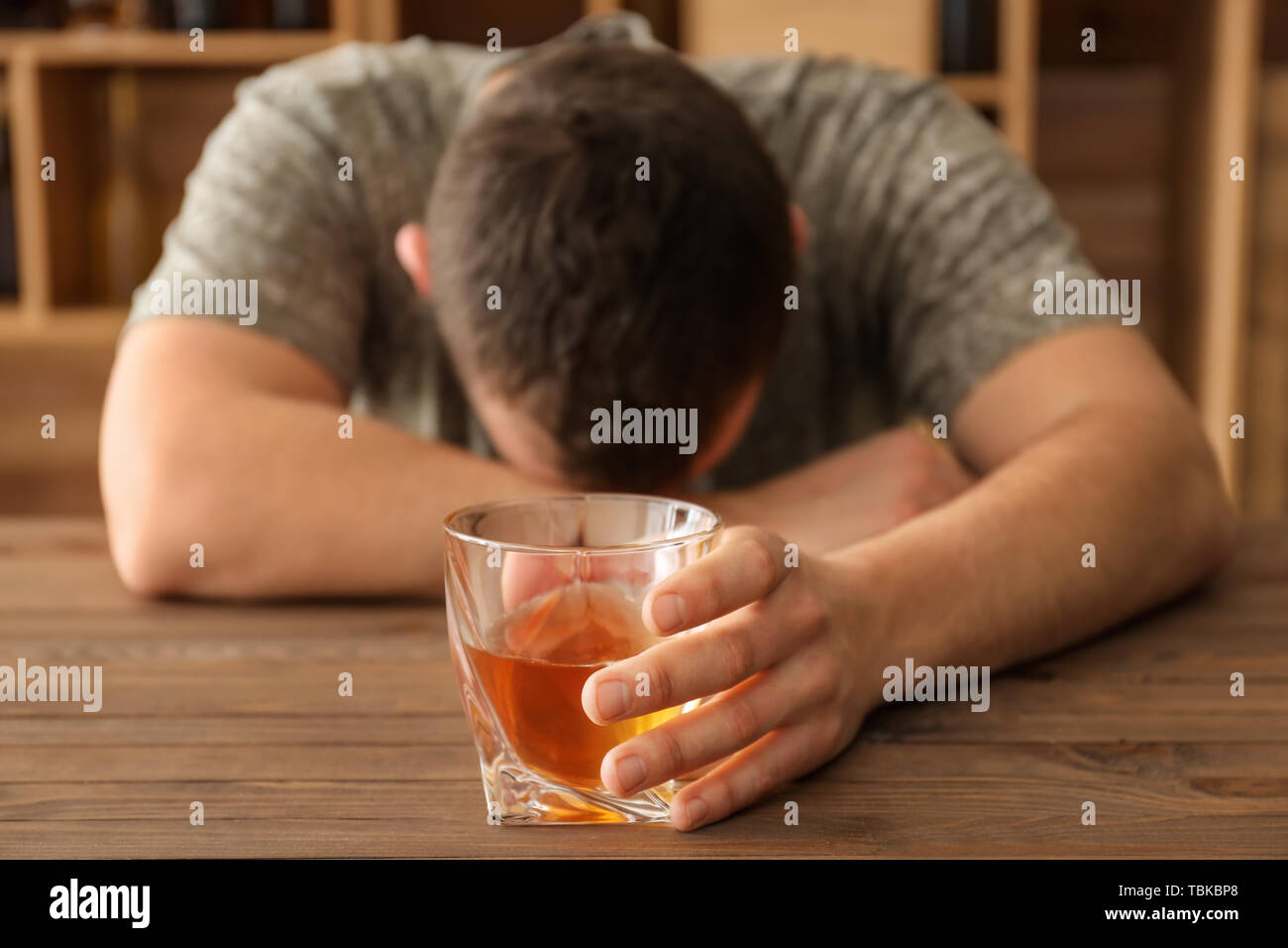 Drunk man with whisky at table in bar Stock Photo - Alamy