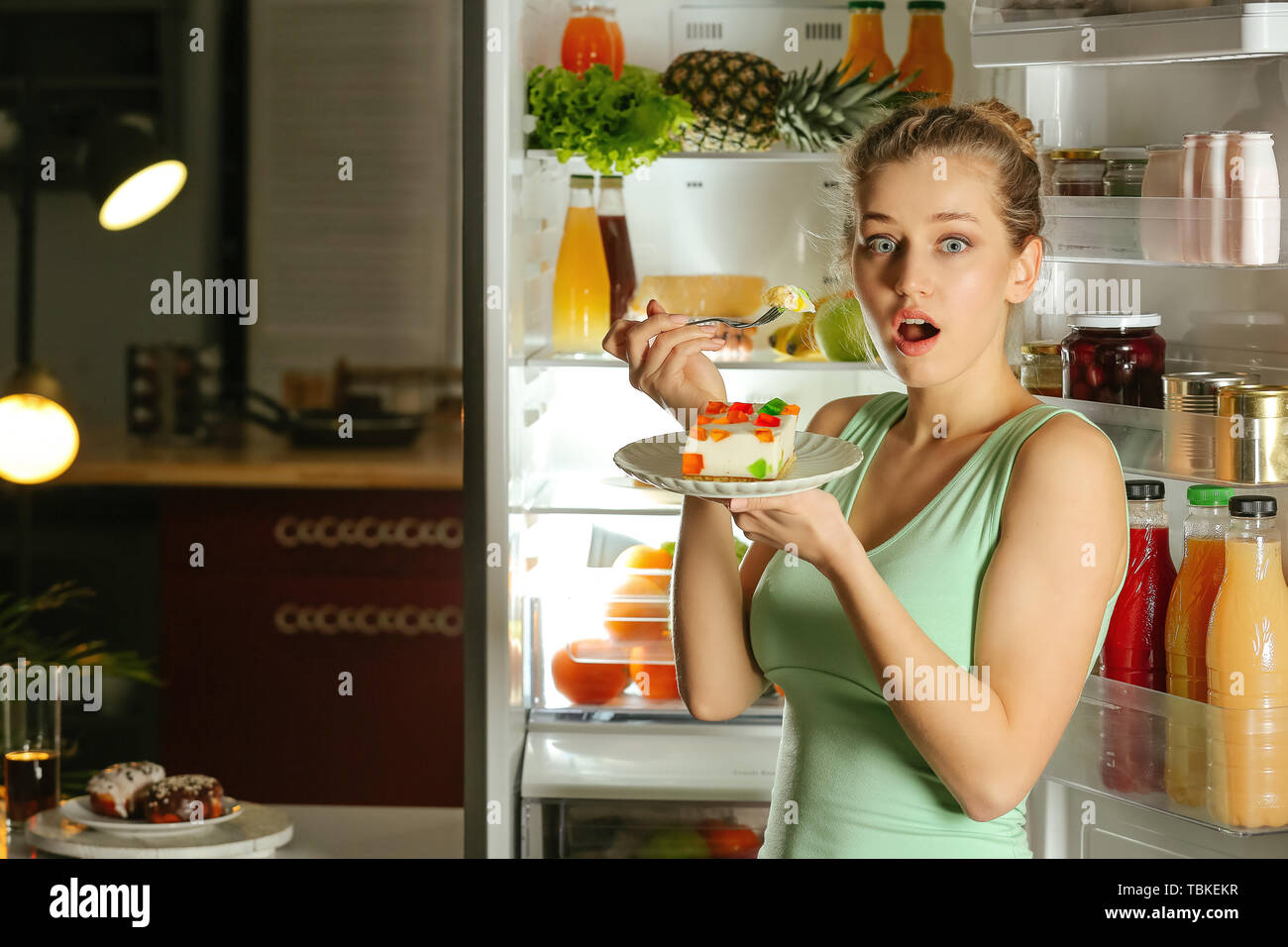 Afraid woman caught in the act of eating tasty unhealthy food near ...