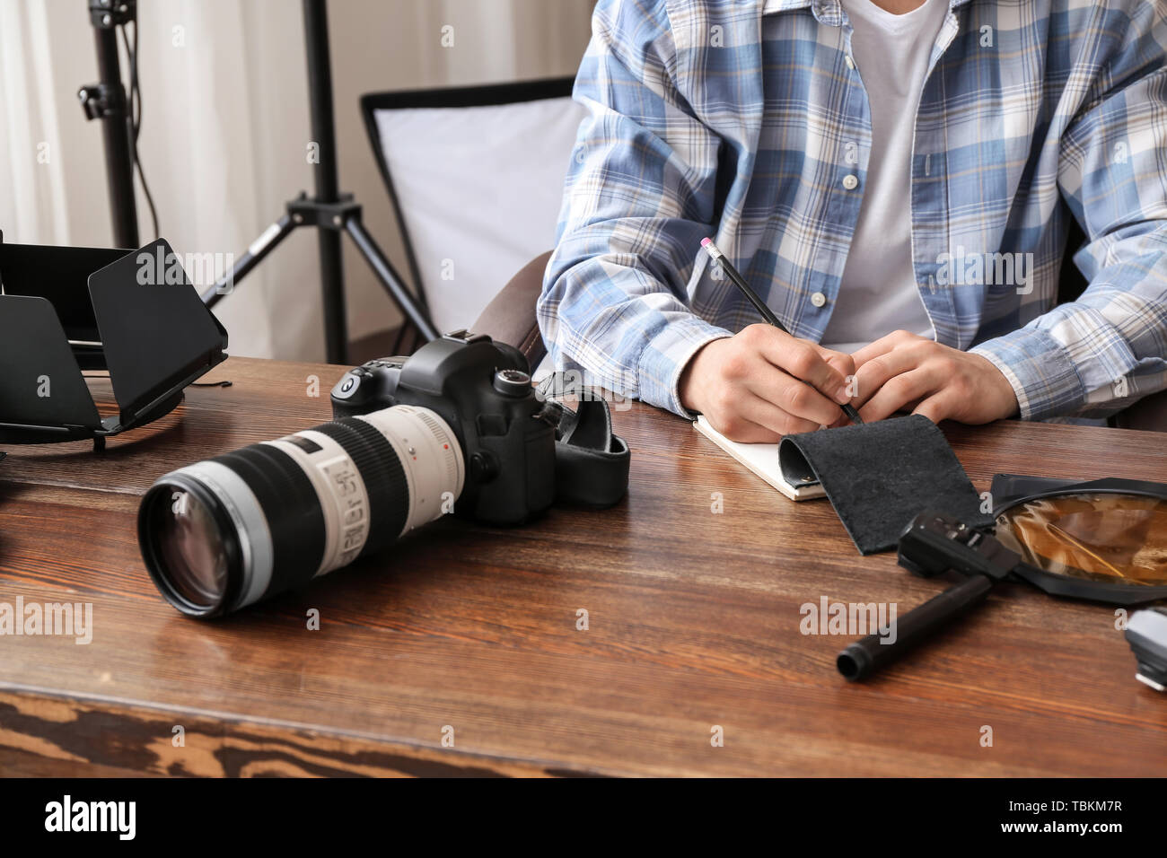 Professional photographer writing in notebook at table Stock Photo - Alamy