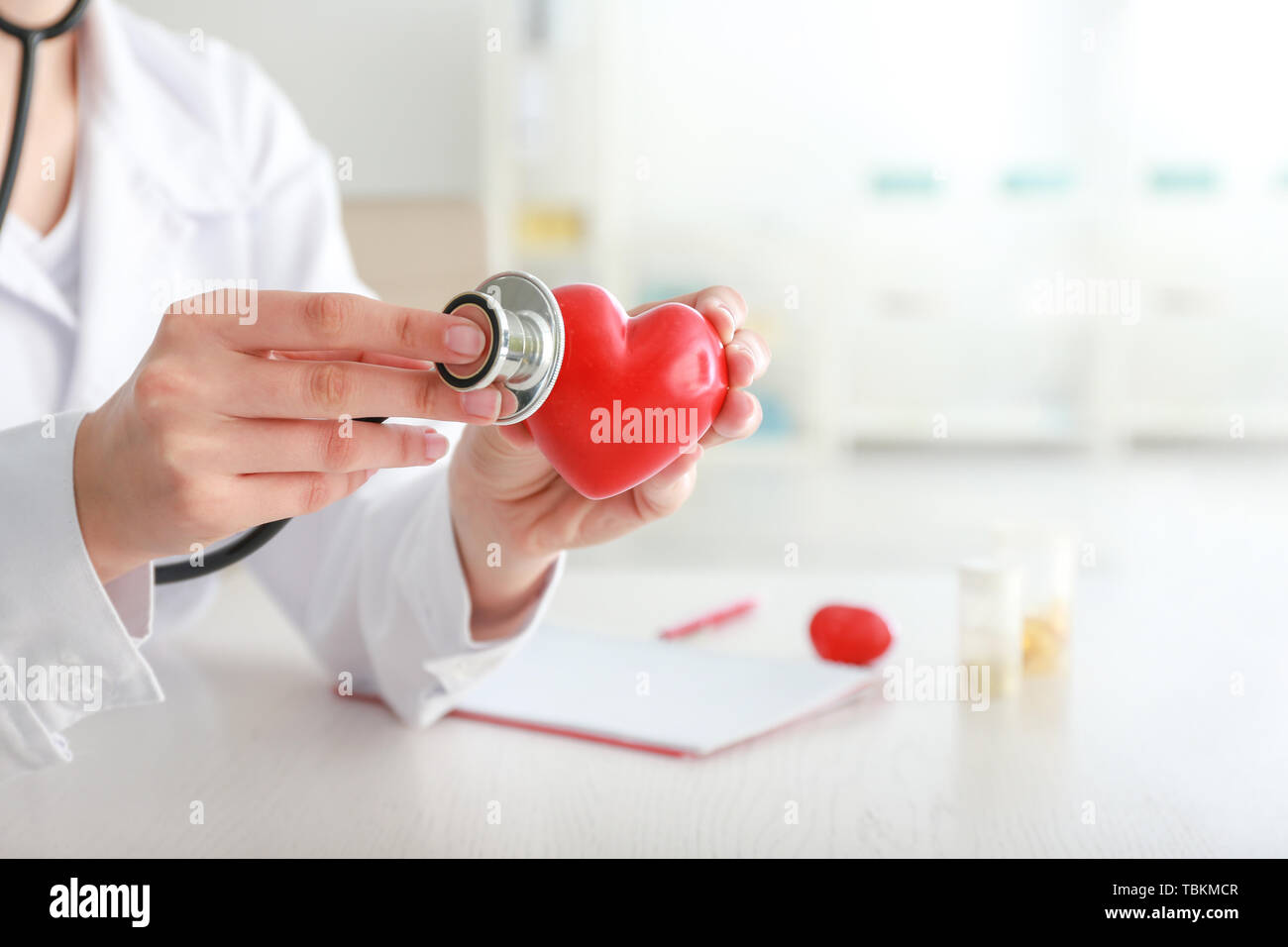 Cardiologist with red heart and stethoscope in clinic Stock Photo - Alamy