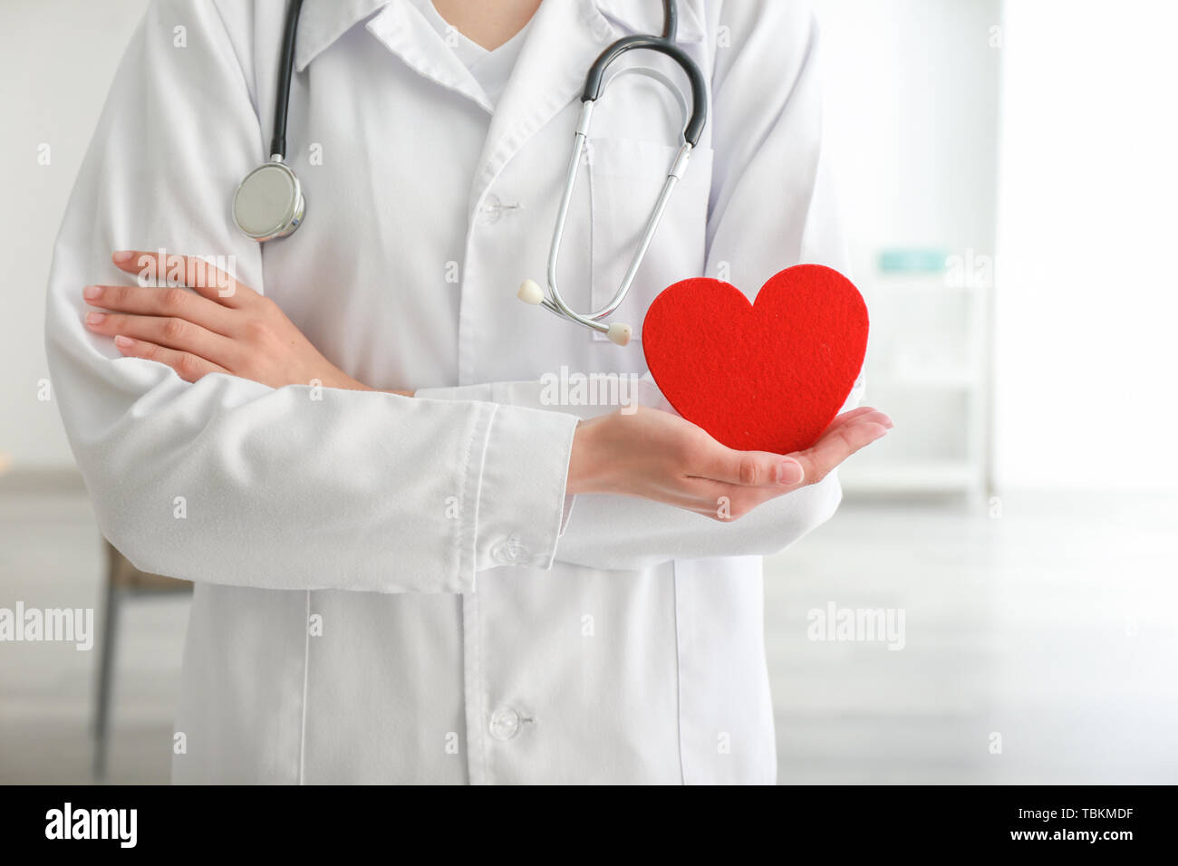 Cardiologist with red heart in clinic Stock Photo - Alamy