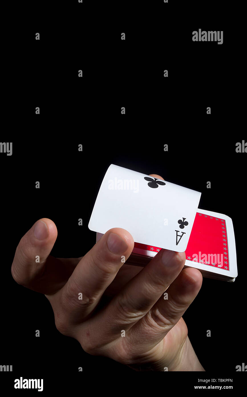Male hand with playing cards on black background Stock Photo - Alamy