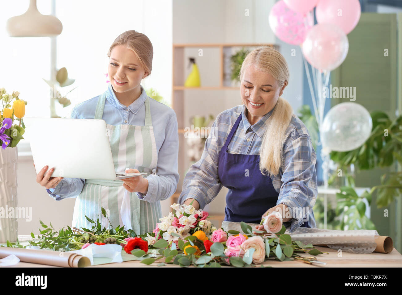 Florists working with laptop in shop Stock Photo - Alamy