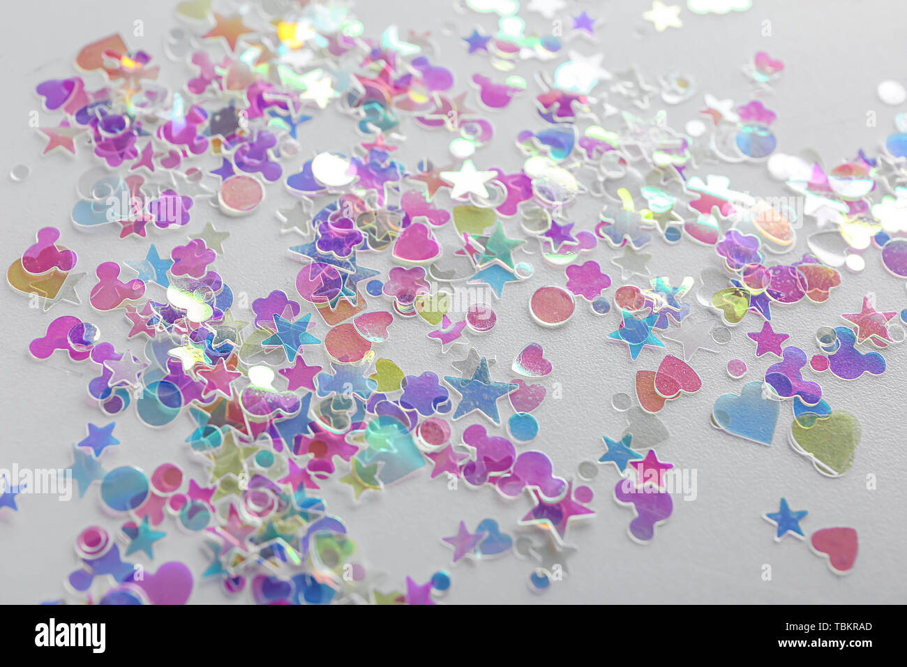 Iridescent sequins on white background Stock Photo - Alamy