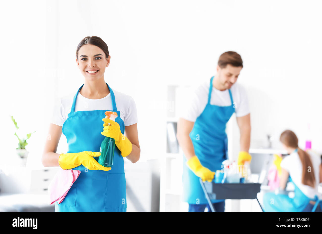 Female janitor and her team in office Stock Photo - Alamy