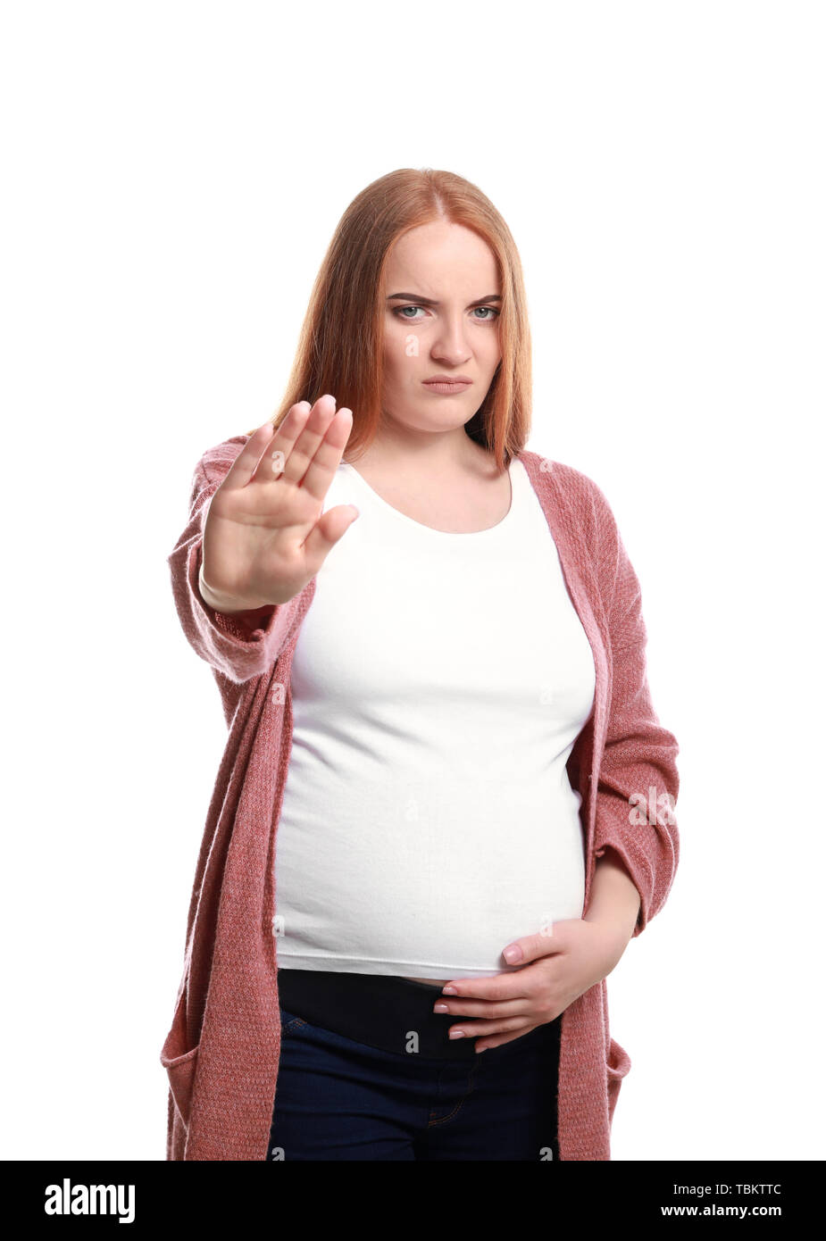 Young pregnant woman showing stop gesture on white background Stock ...