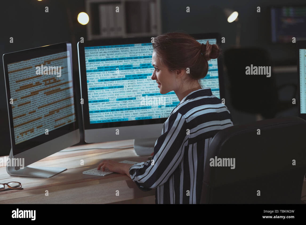 Female programmer working in office at night Stock Photo - Alamy