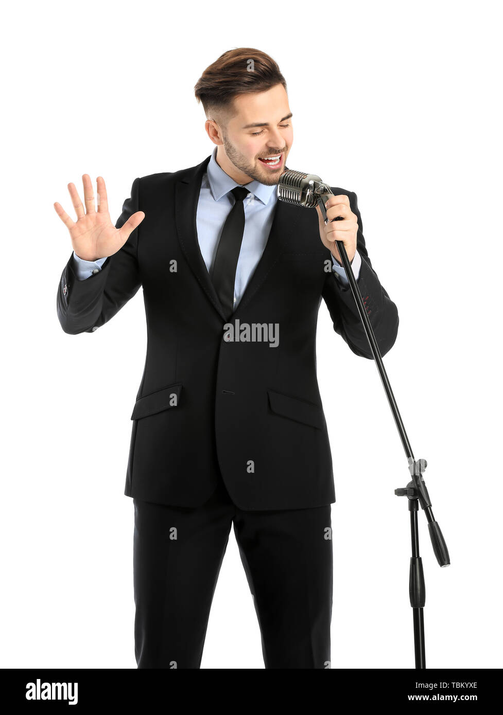 Handsome male singer with microphone on white background Stock Photo ...