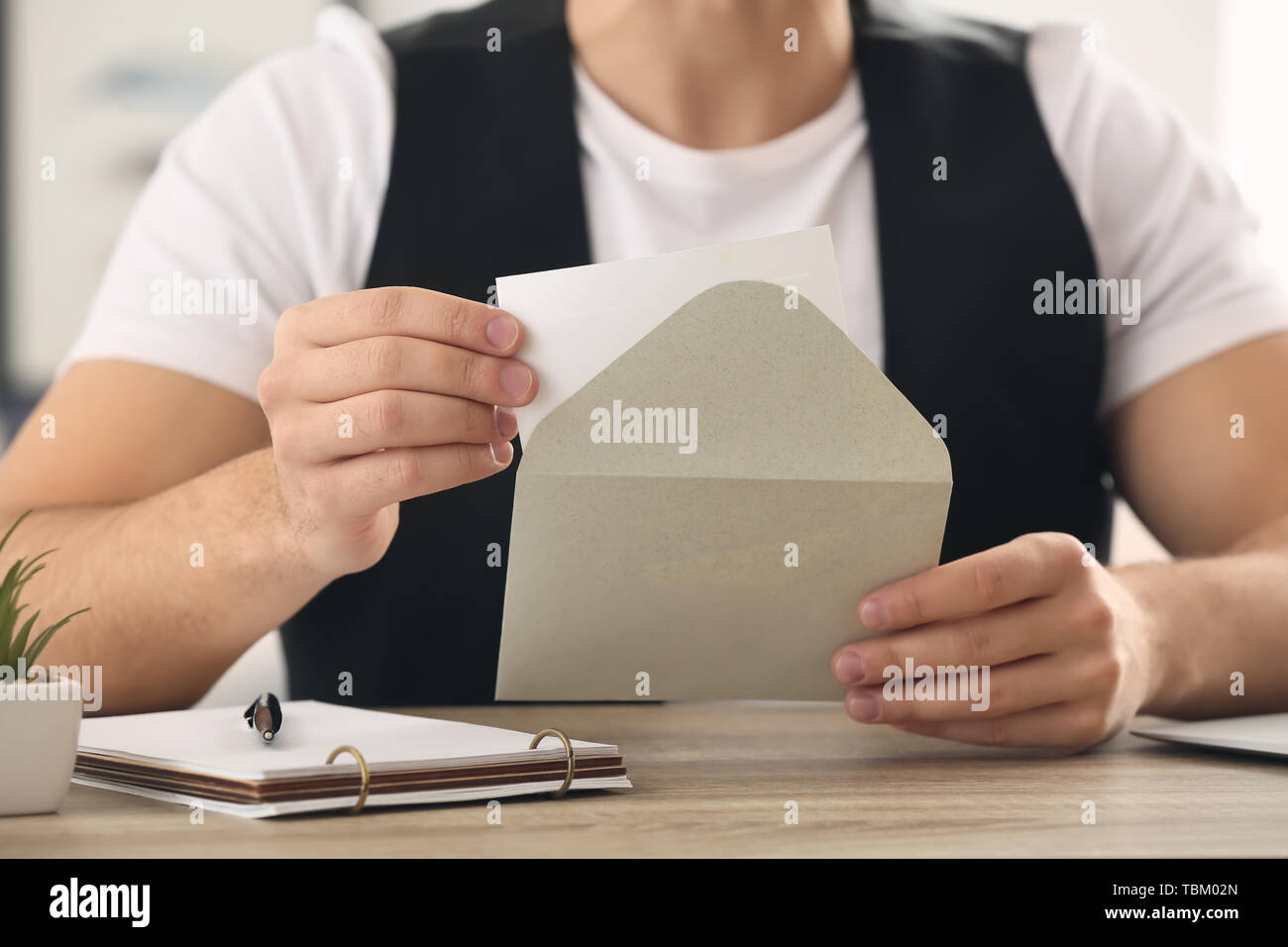 Young man opening envelope with invitation at home, closeup Stock Photo ...